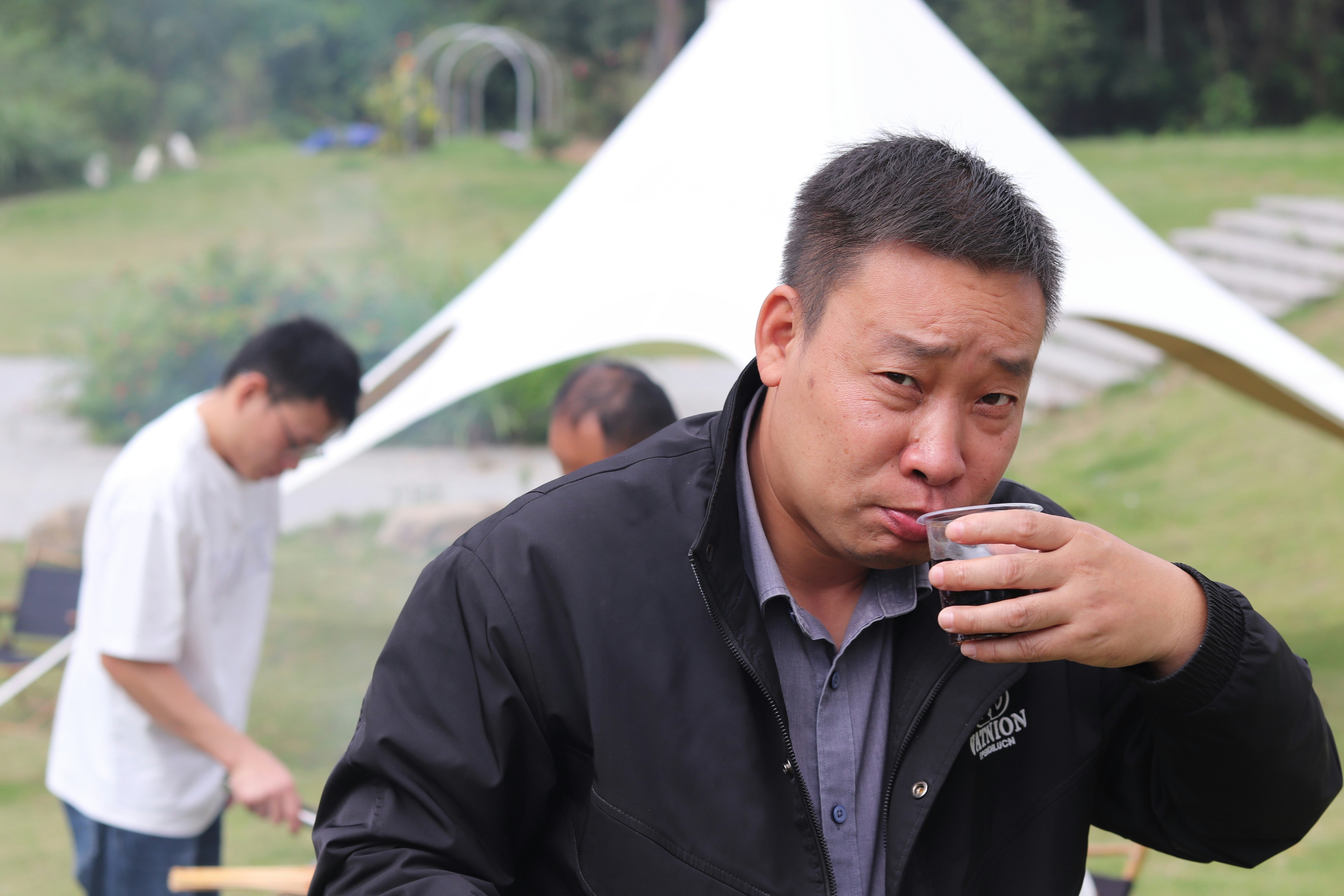 Face with a drink: a candid moment of focus outdoors