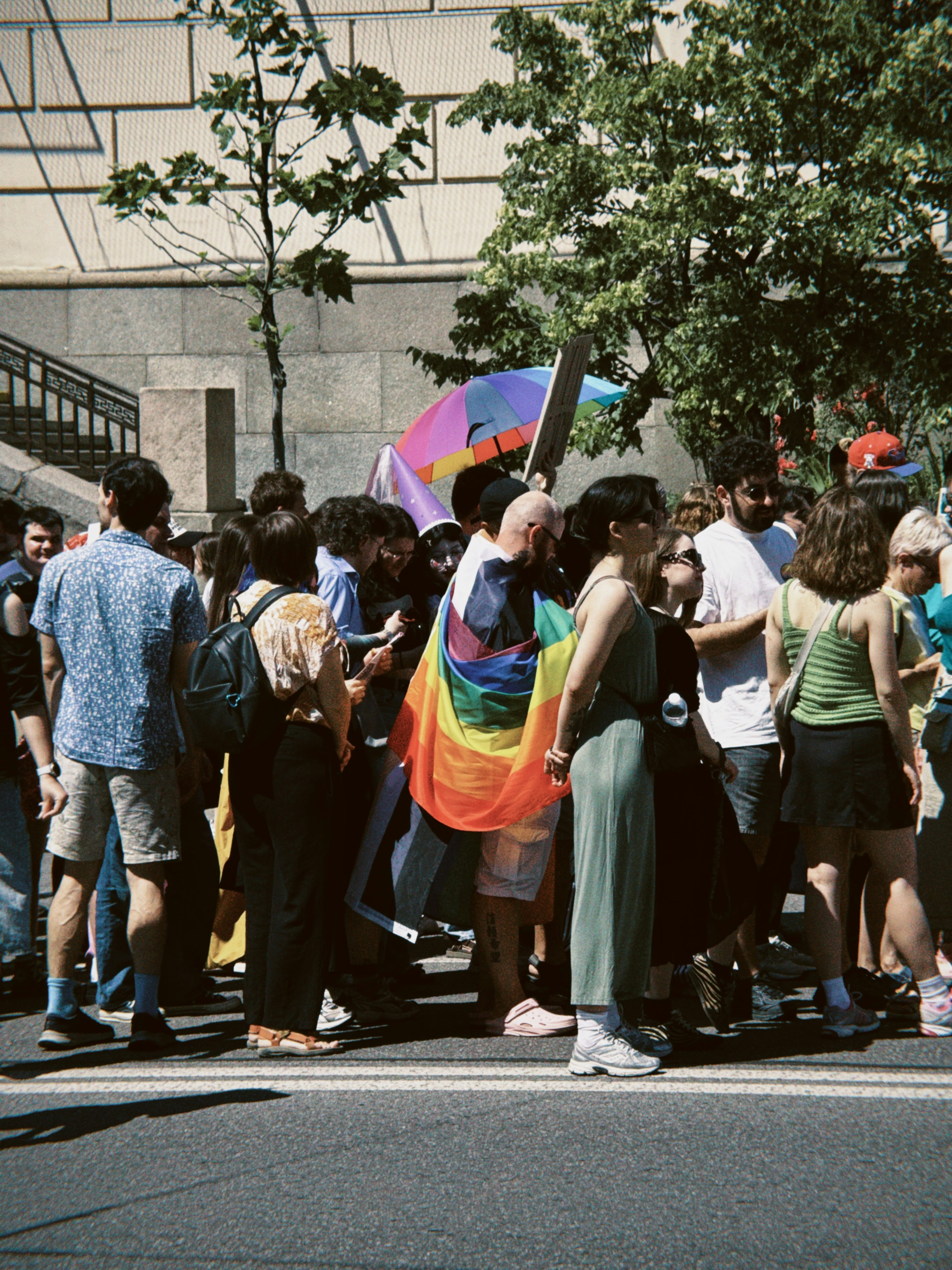 Rainbow-clad Pride Crowd at a City Street Corner