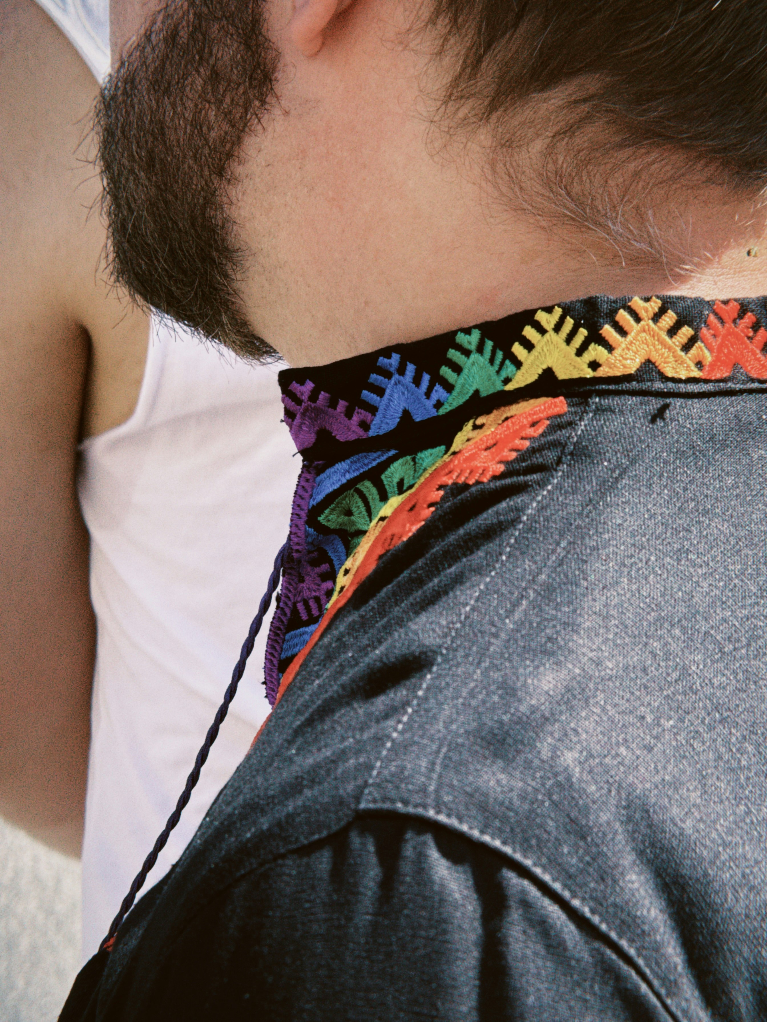 Colorful trim on dark shirt frames the shoulder and neck
