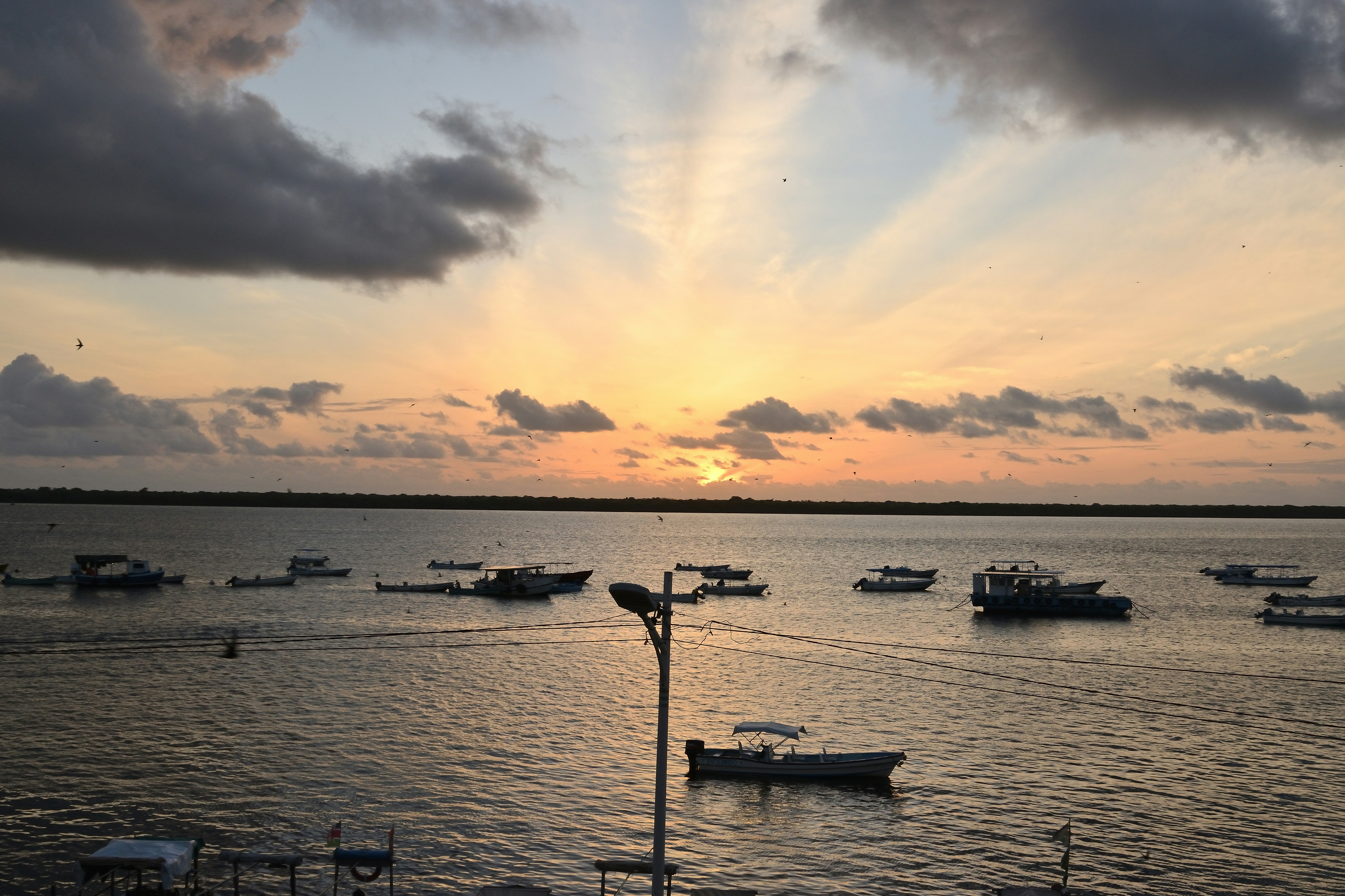 Sunset Over a Quiet Harbor: Boats Silhouetted Against Radiant Sky