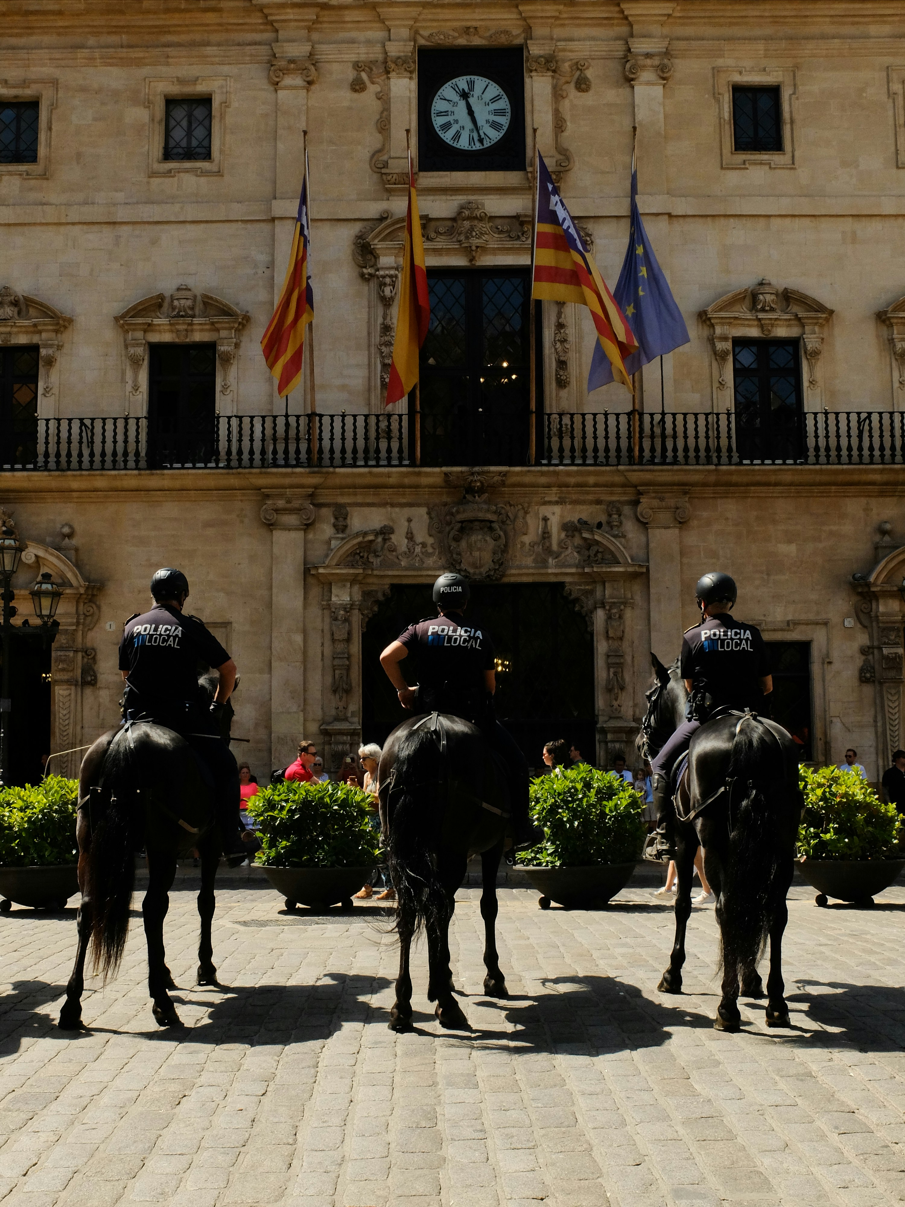 Three Mounted Officers Guard a Historic Building Front