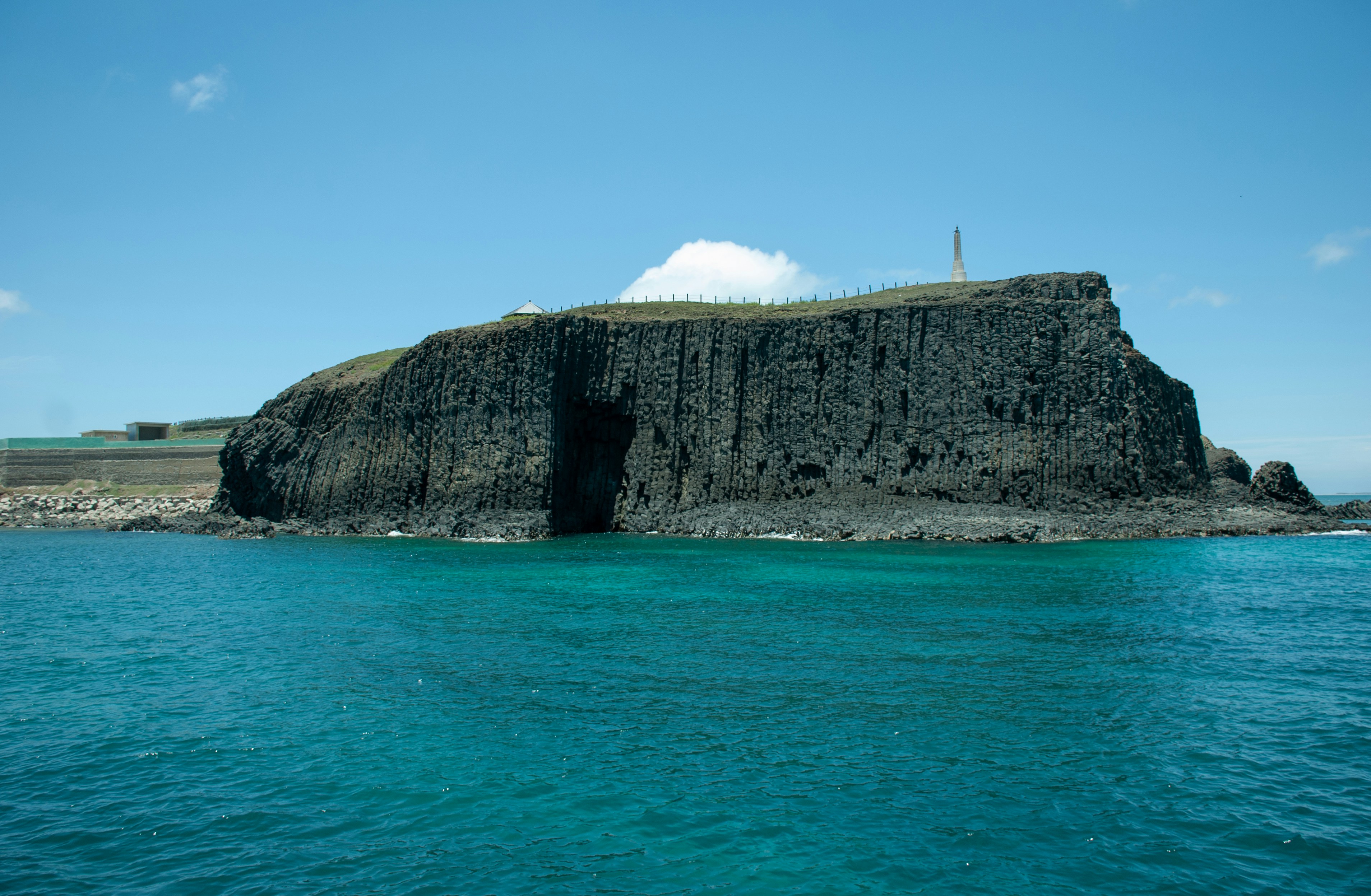 Midday Cliff Fort: A Sea-Washed Monolith Stands Against Turquoise Waters