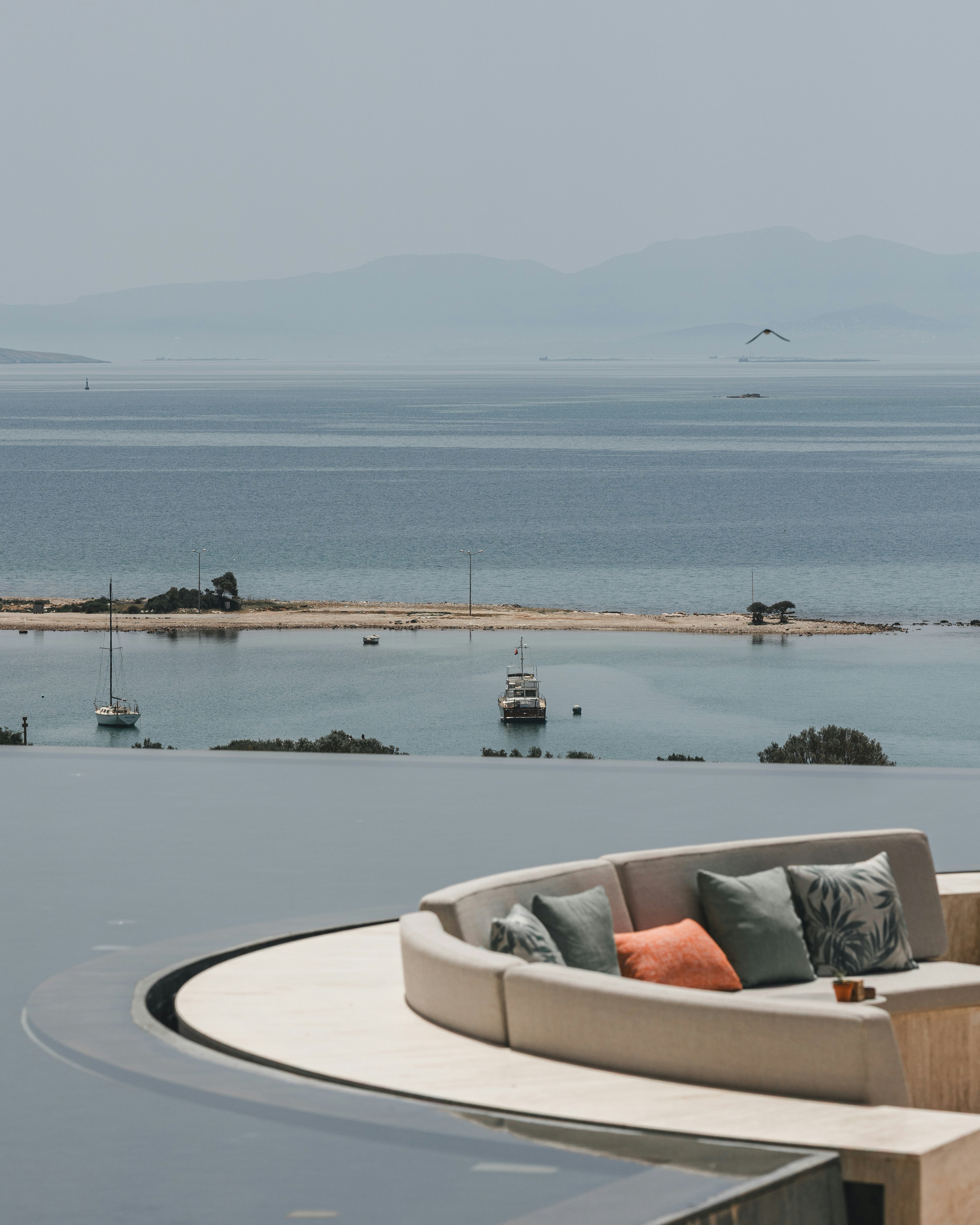 Serene Infinity: Lounge Seating Overlooking a Calm Coastal Scene