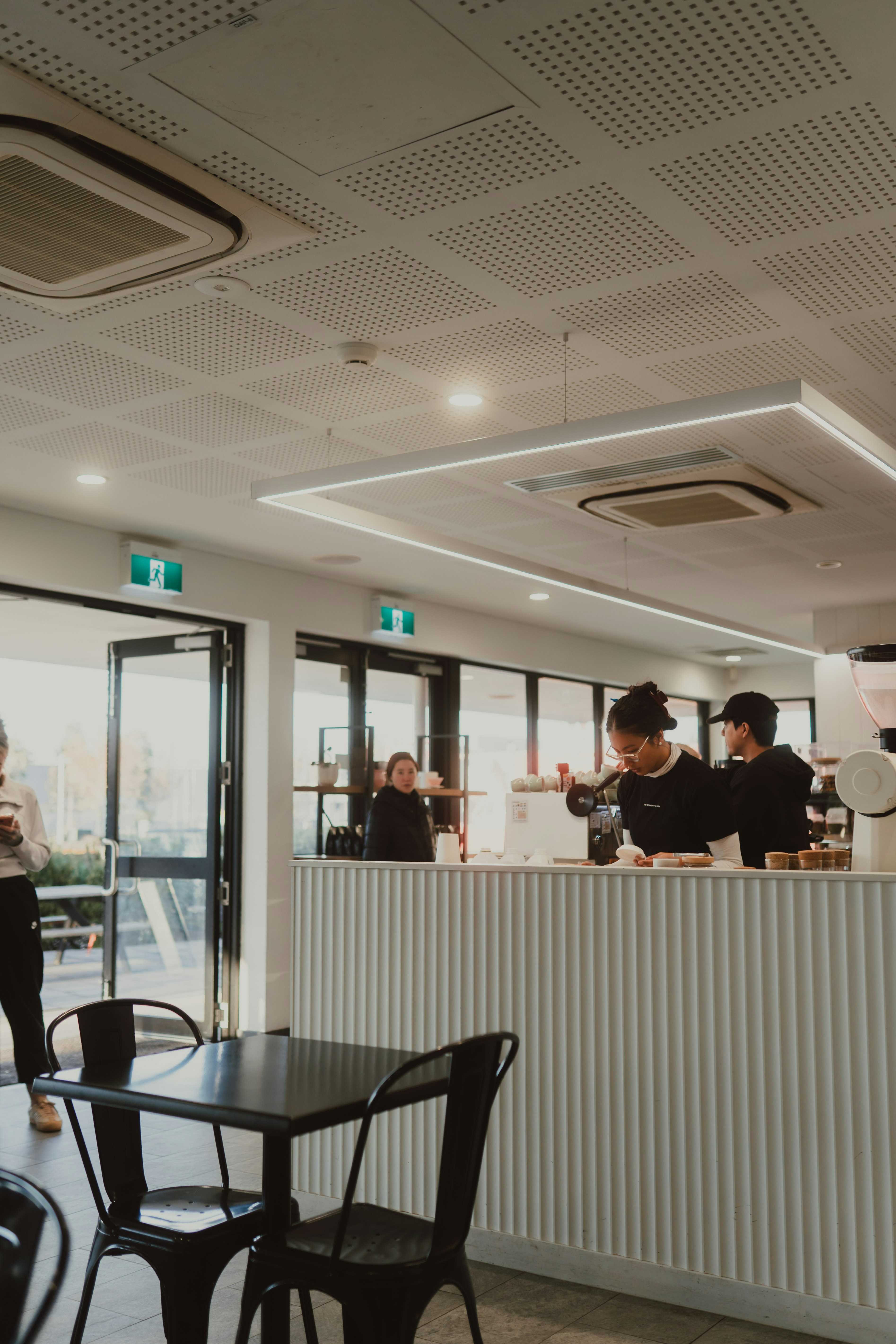 Cafe Baristas at Work: Striped Counter, Soft Lighting, and Quiet Activity