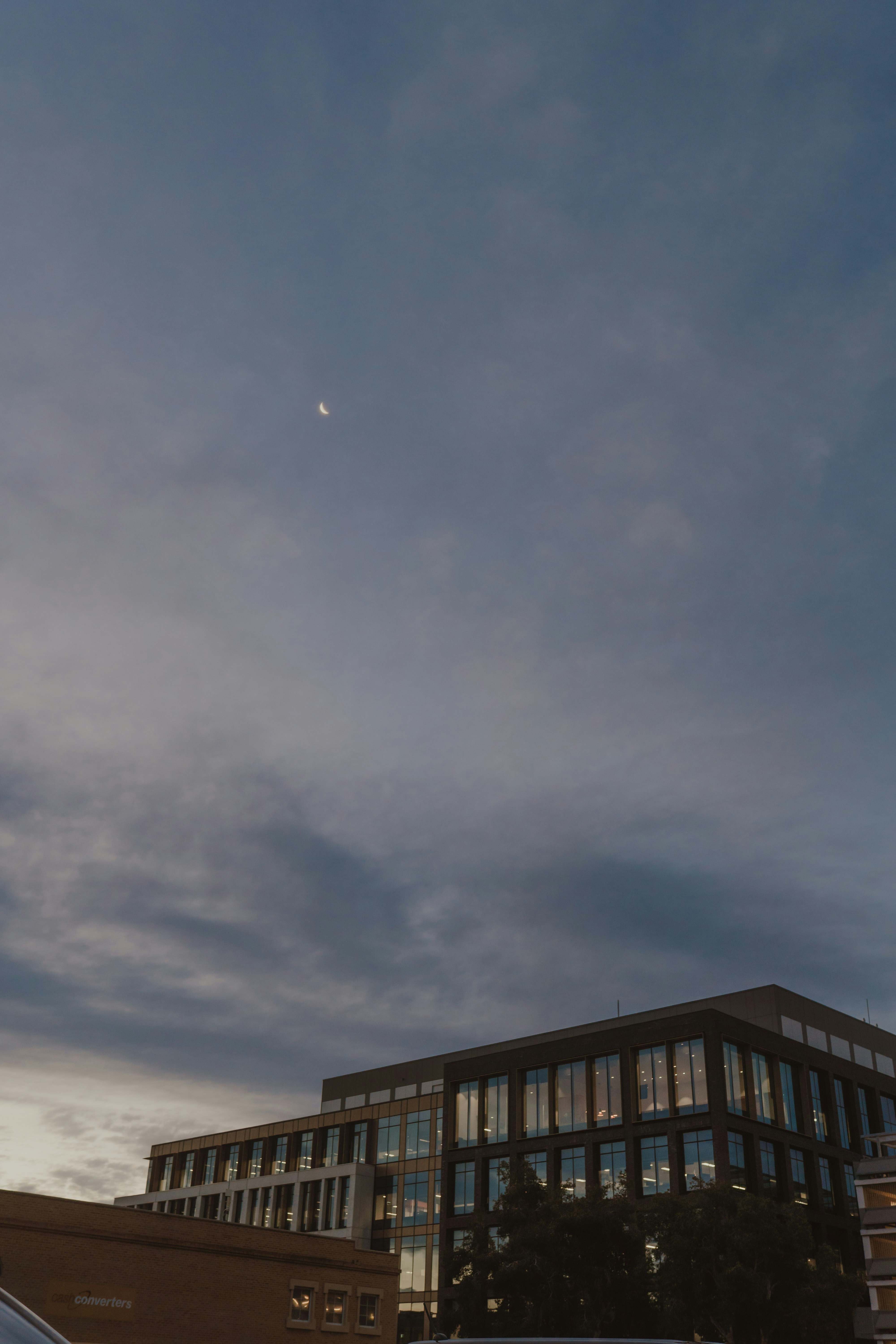 Moonlit Office Skyscraper silhouette under a pale evening sky