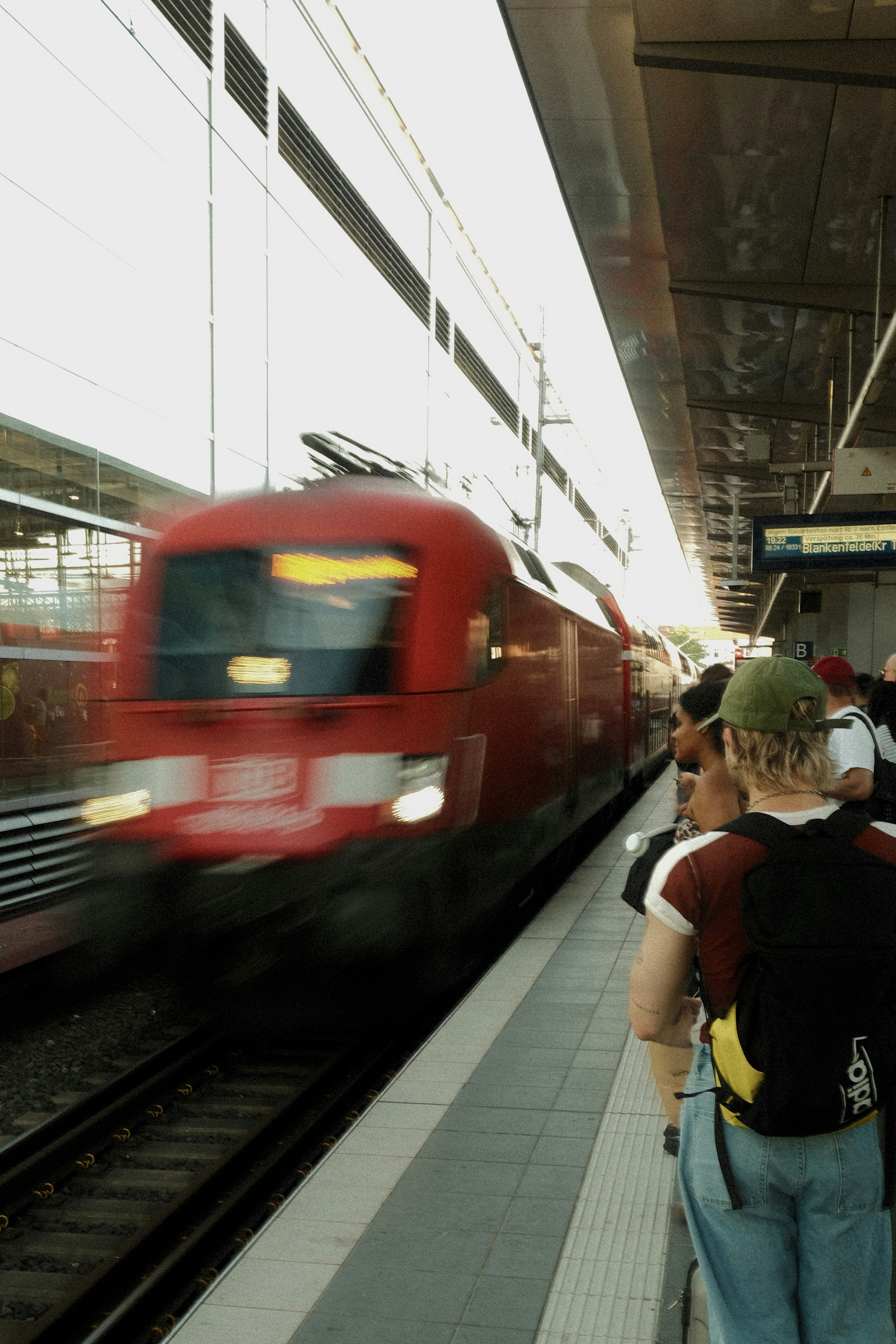 Red Train at Platform: Faces Turned Toward Arrival