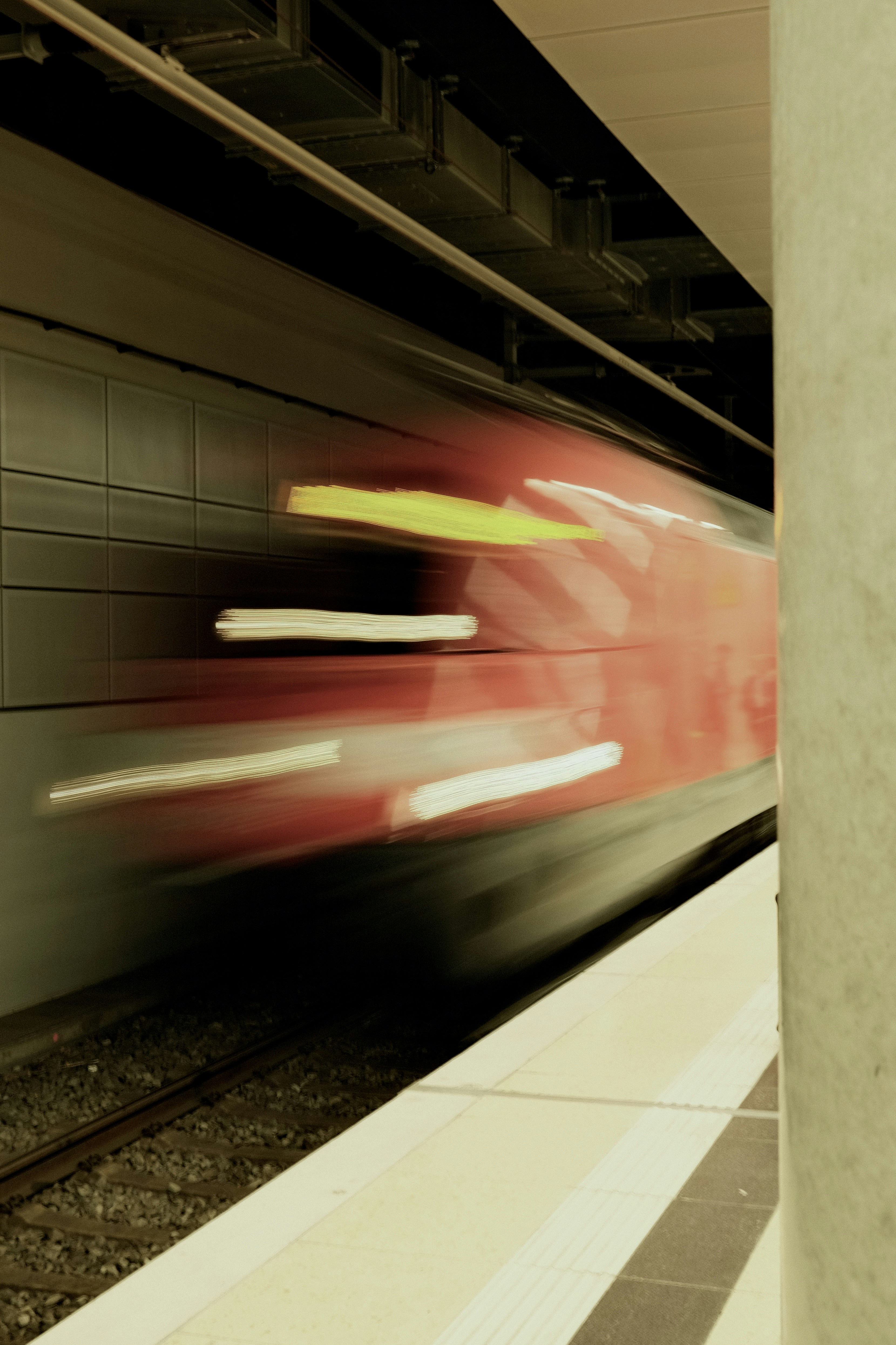 Speed in Motion: Blurred Red Locomotive Slicing Through the Platform