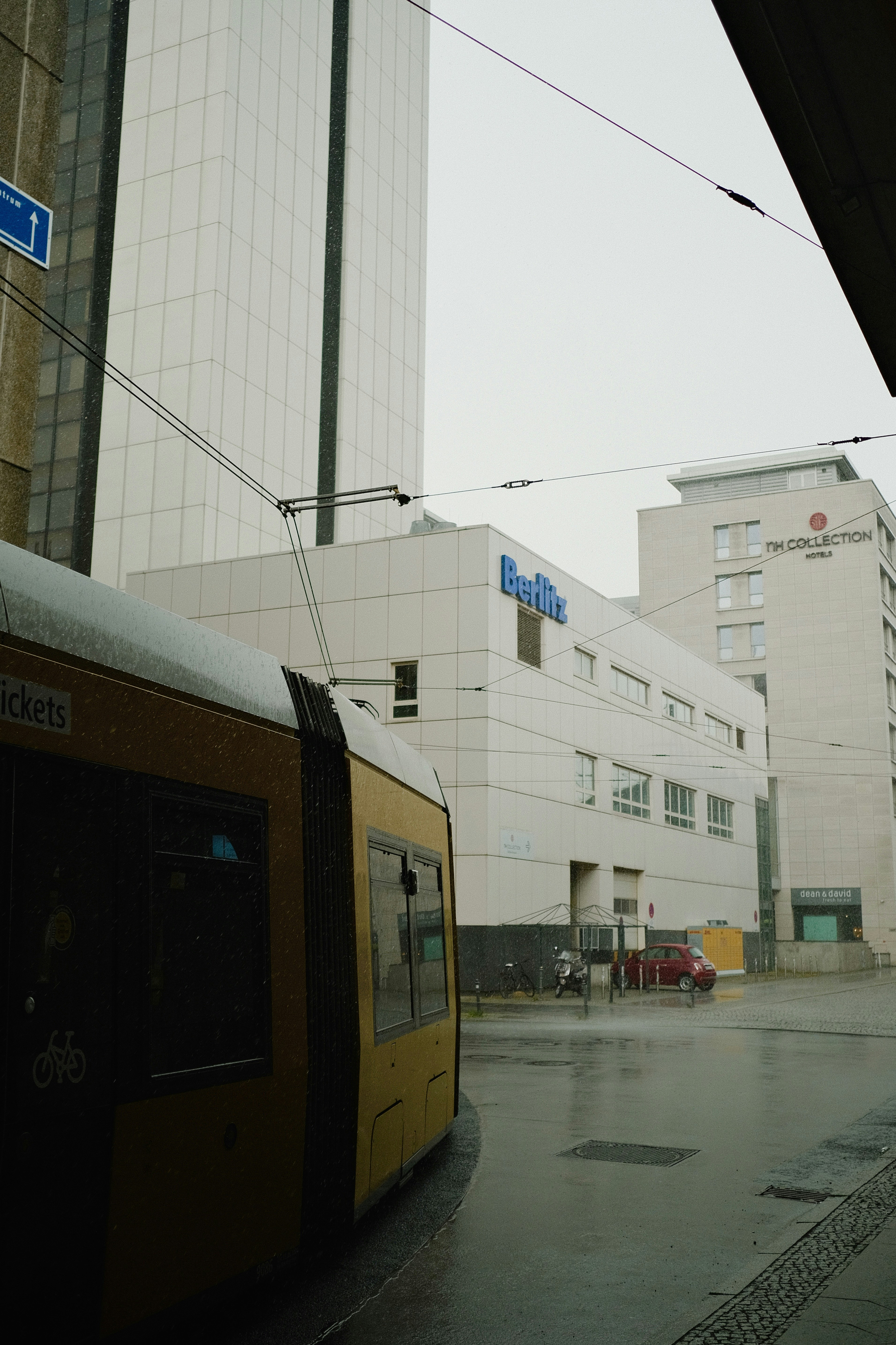 Yellow Tram at the Edge of a Modern Cityscape in Rain