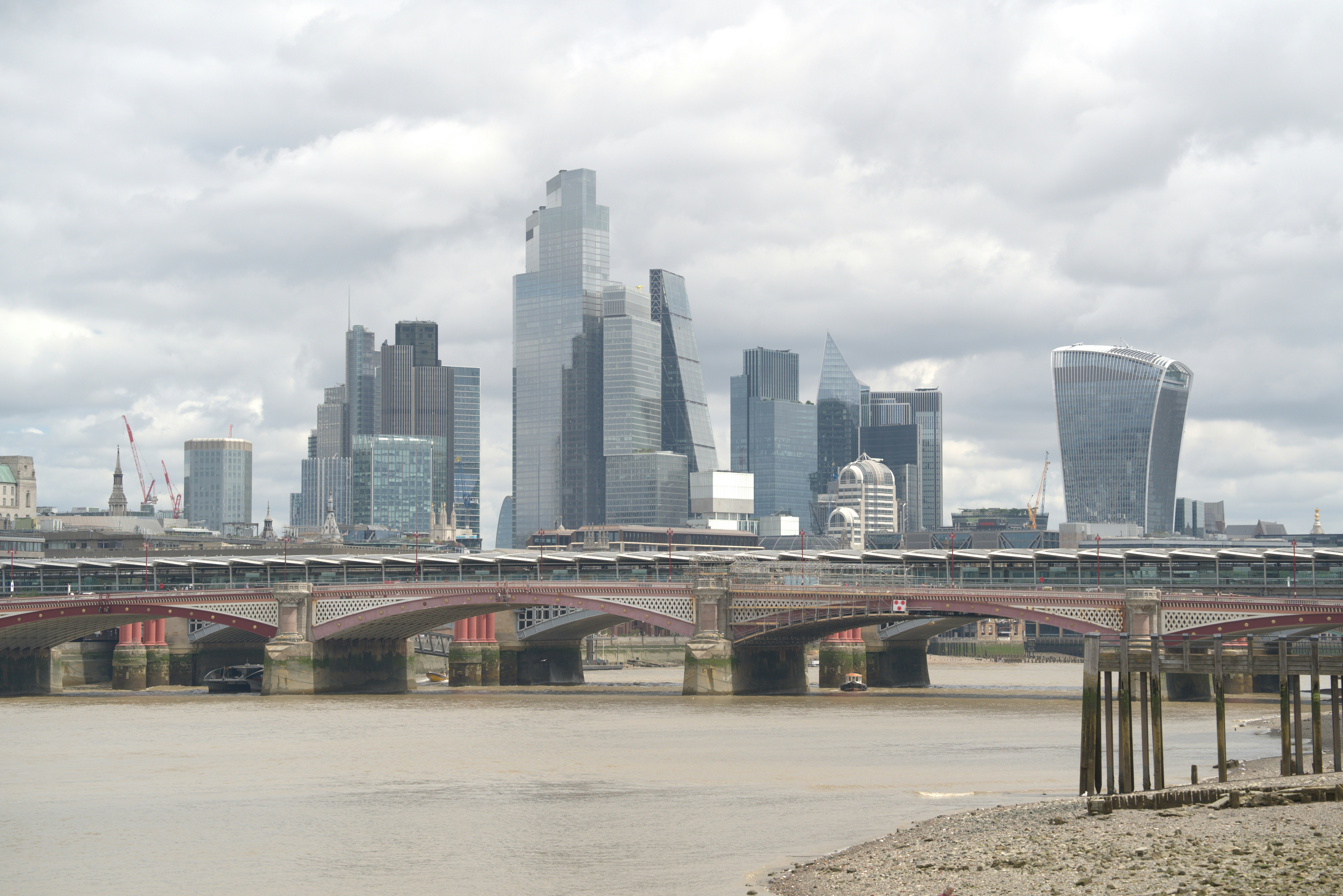 Urban Horizon over Thames: Classic Towers Above a Brick-Arched Riverside