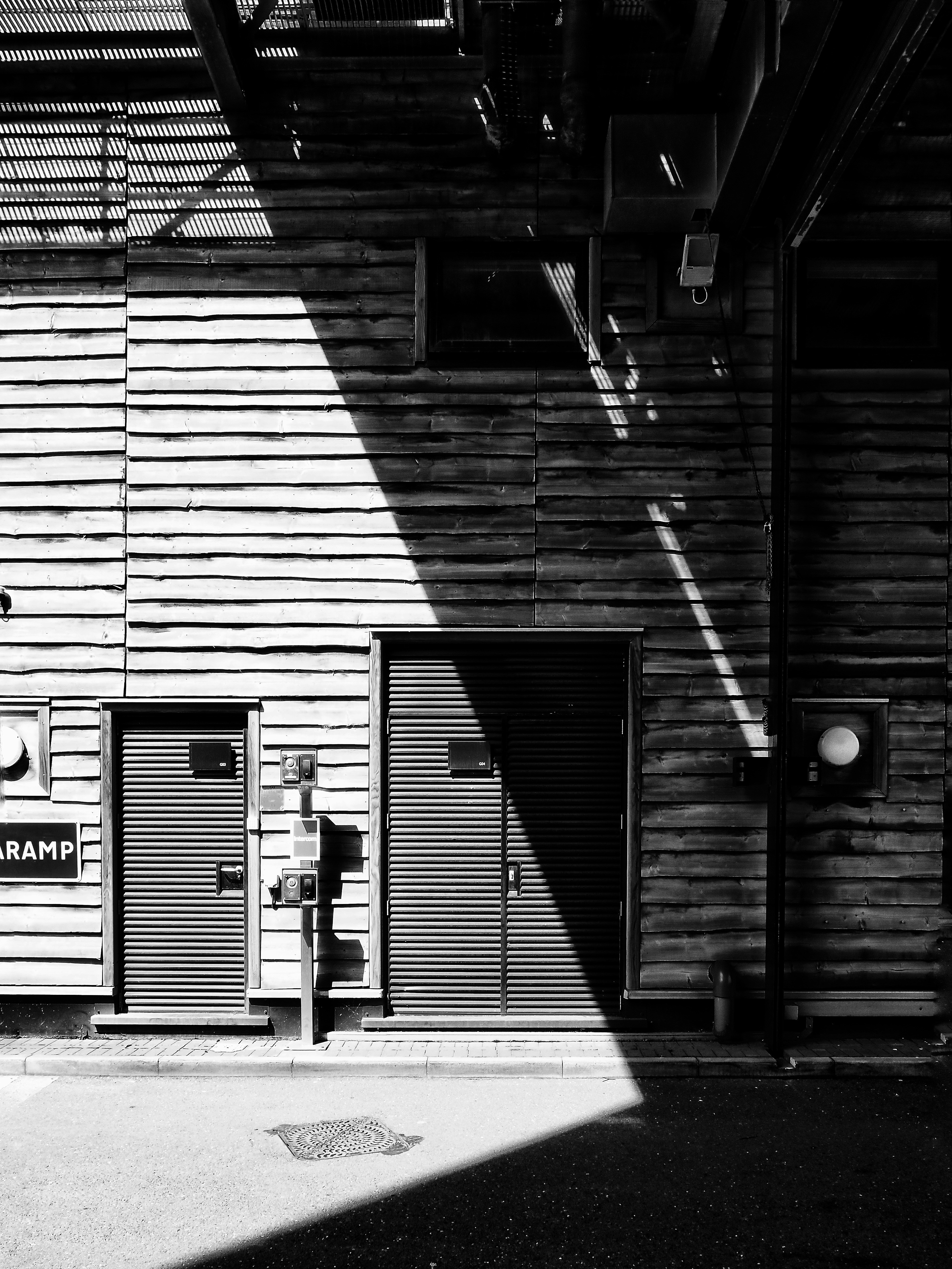 Shadowed Doors and Narrow Light: An Industrial Portrait in Black and White