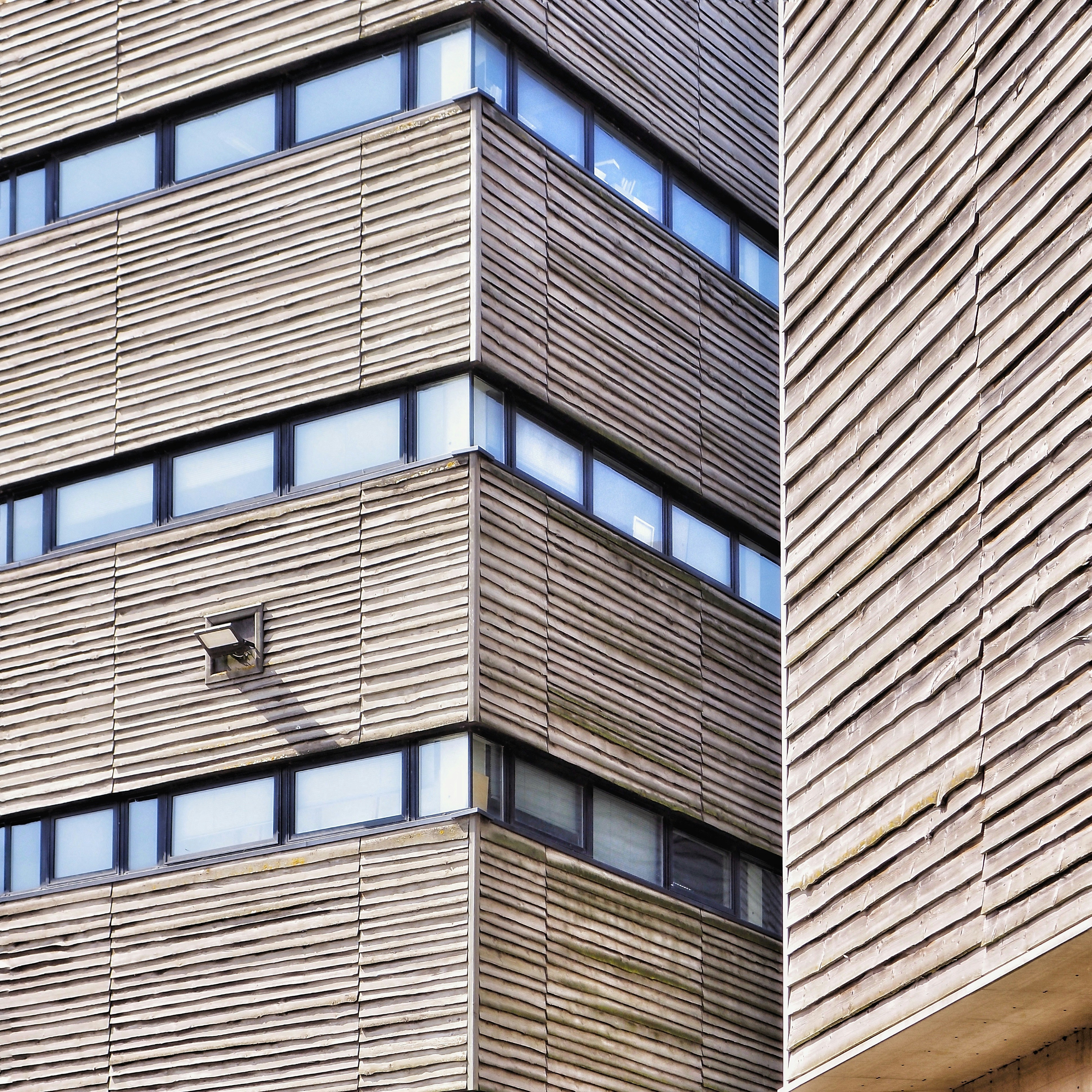 Corner Layers: Brick Strata and Glass Slits on a Modern Facade