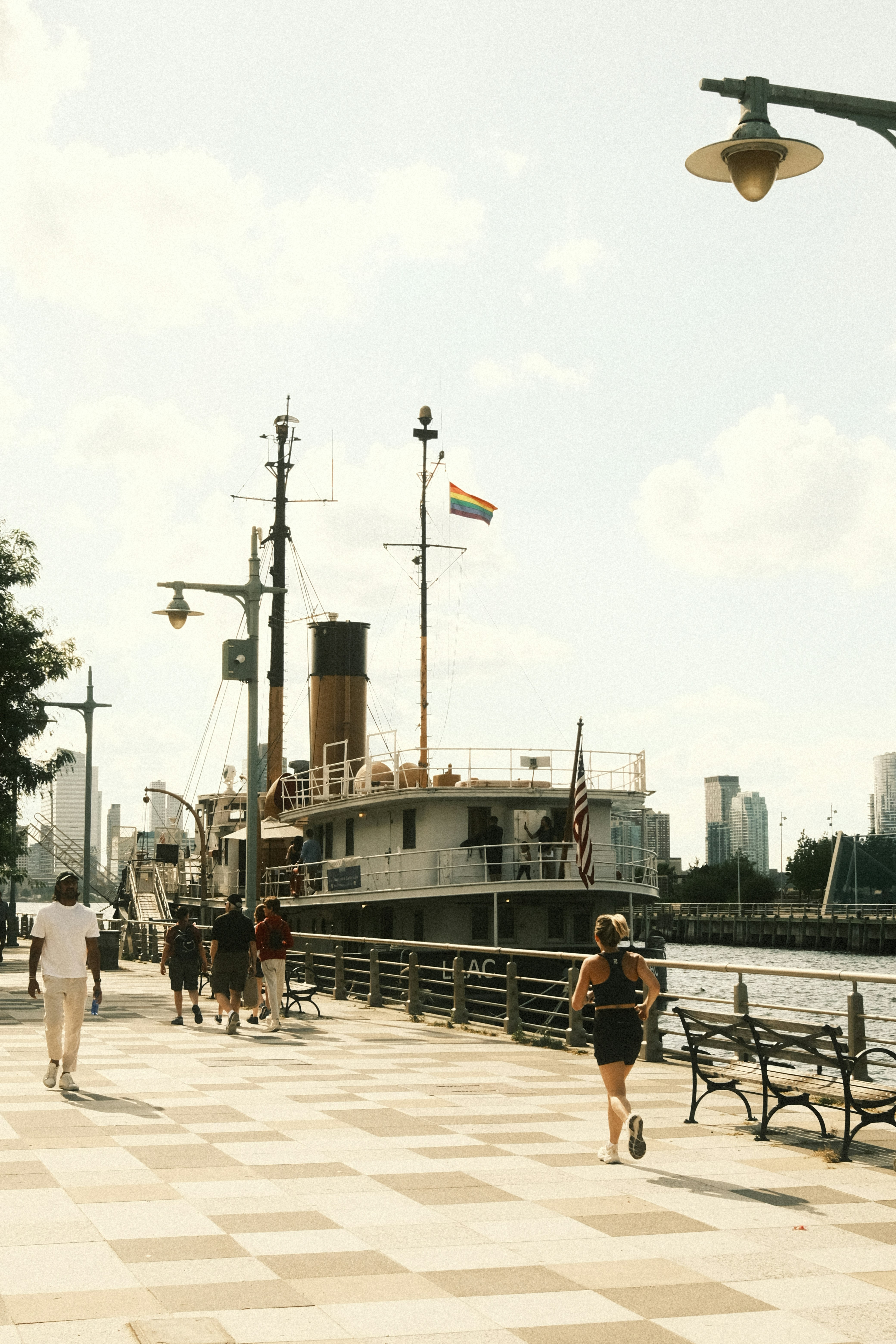 Sunlit Riverside Stroll by a Historic Boat