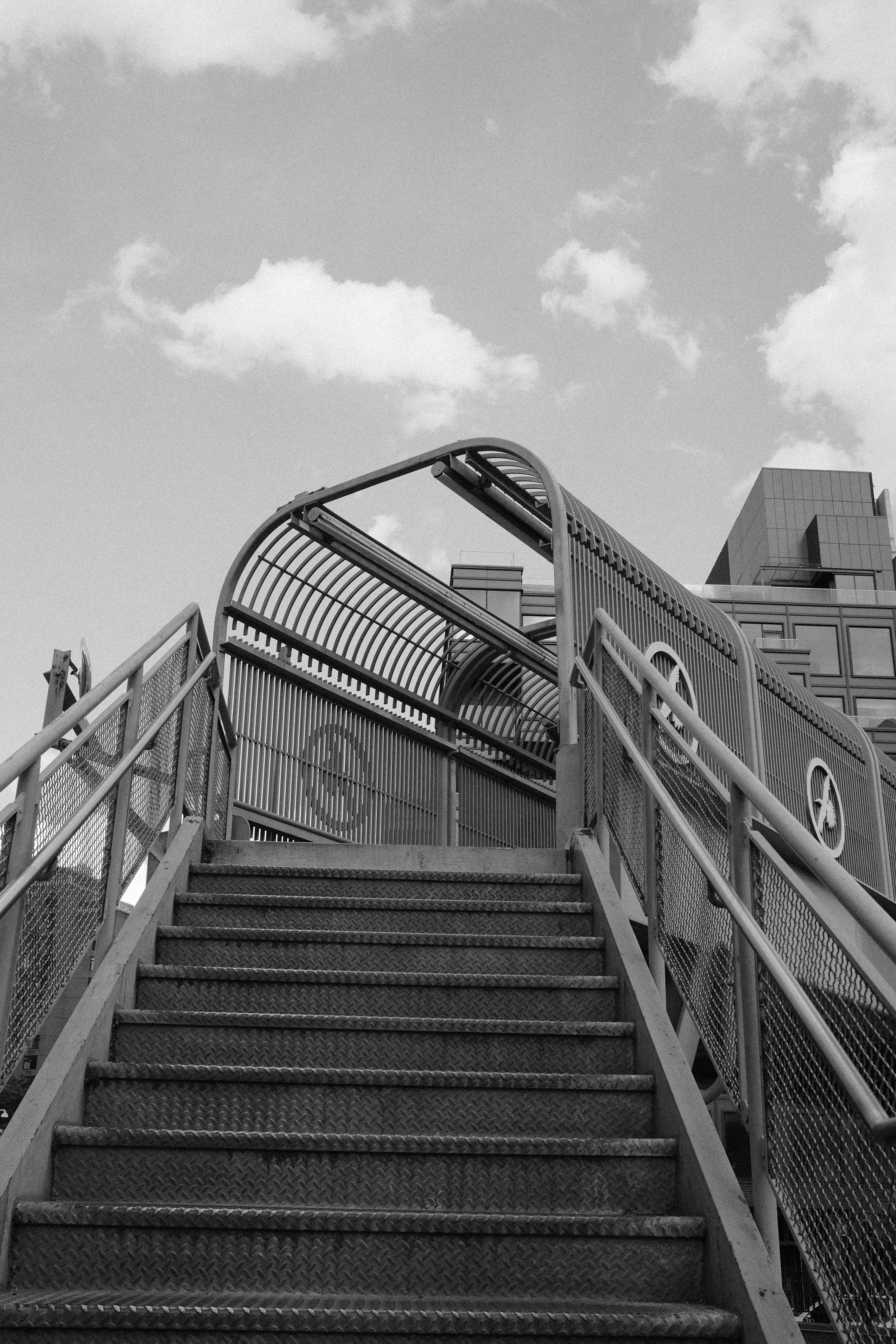 Ascending toward the city grid: stairs and railings framing a modern rooftop walk