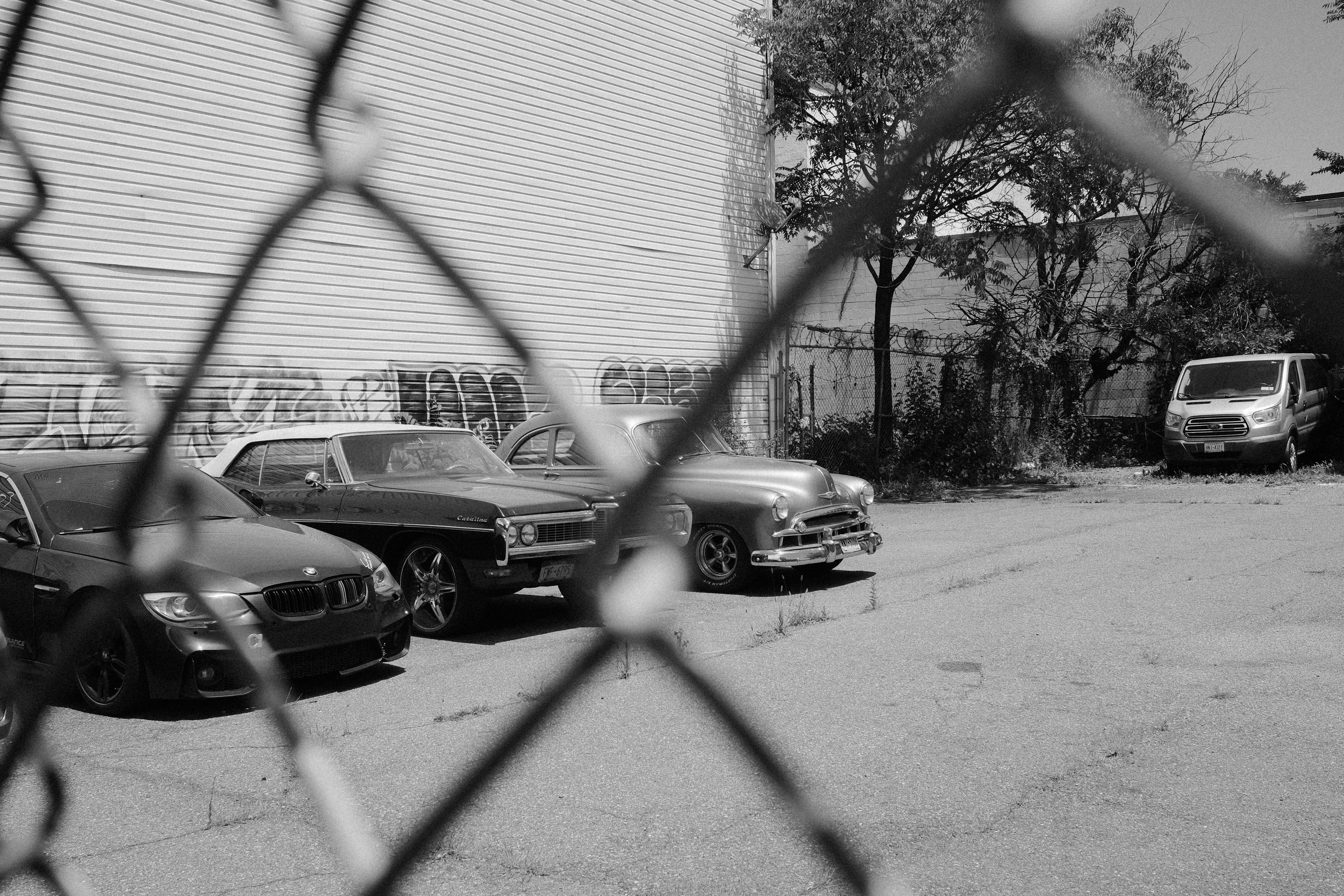 Cars Through the Chain-Link: A Quiet Parking Lot Framed by the Fence