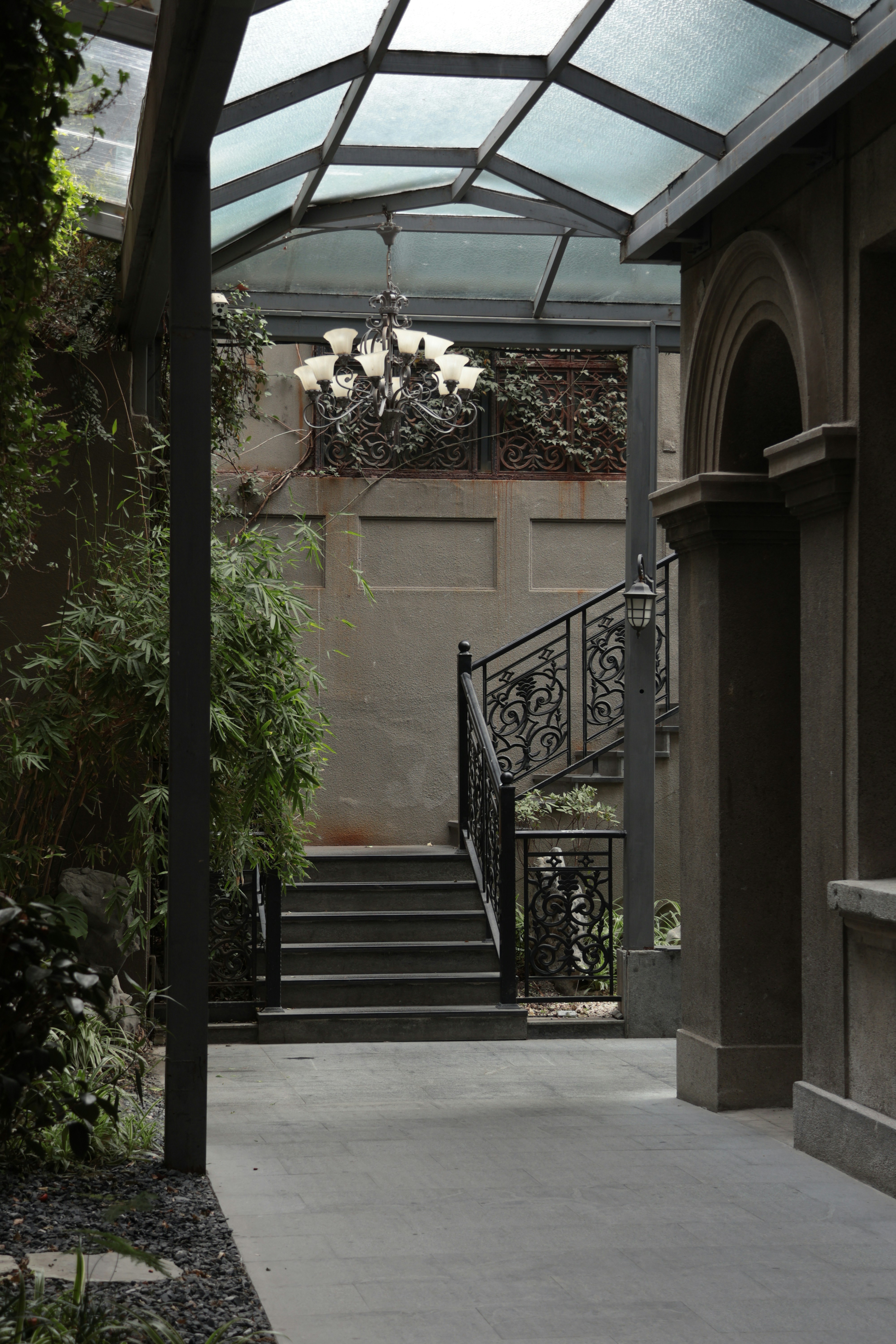 Arched Corridor Framed by Staircase and Glass Roof