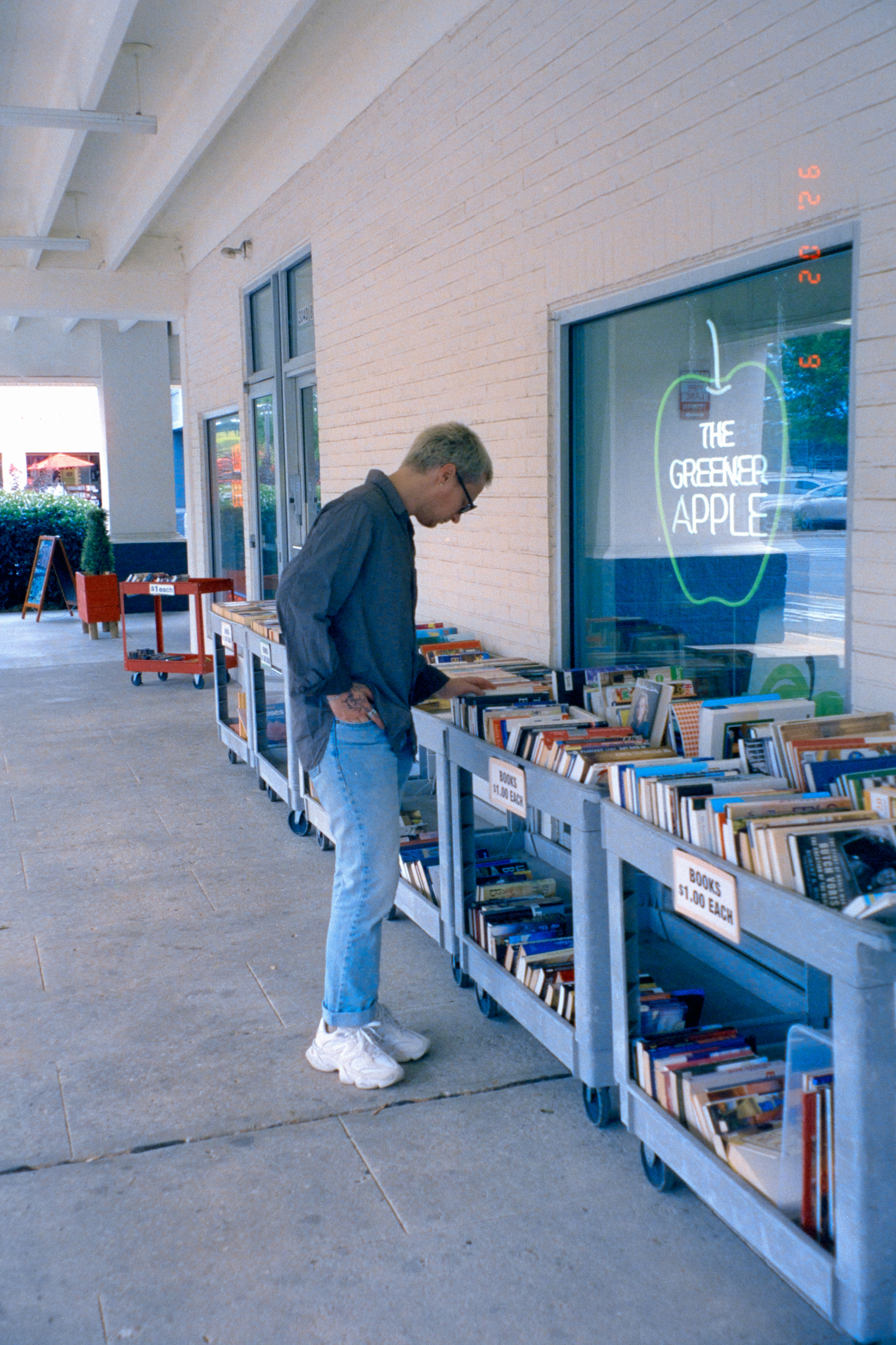 A Quiet Perusal: Man Browses Books Outside a Storefront