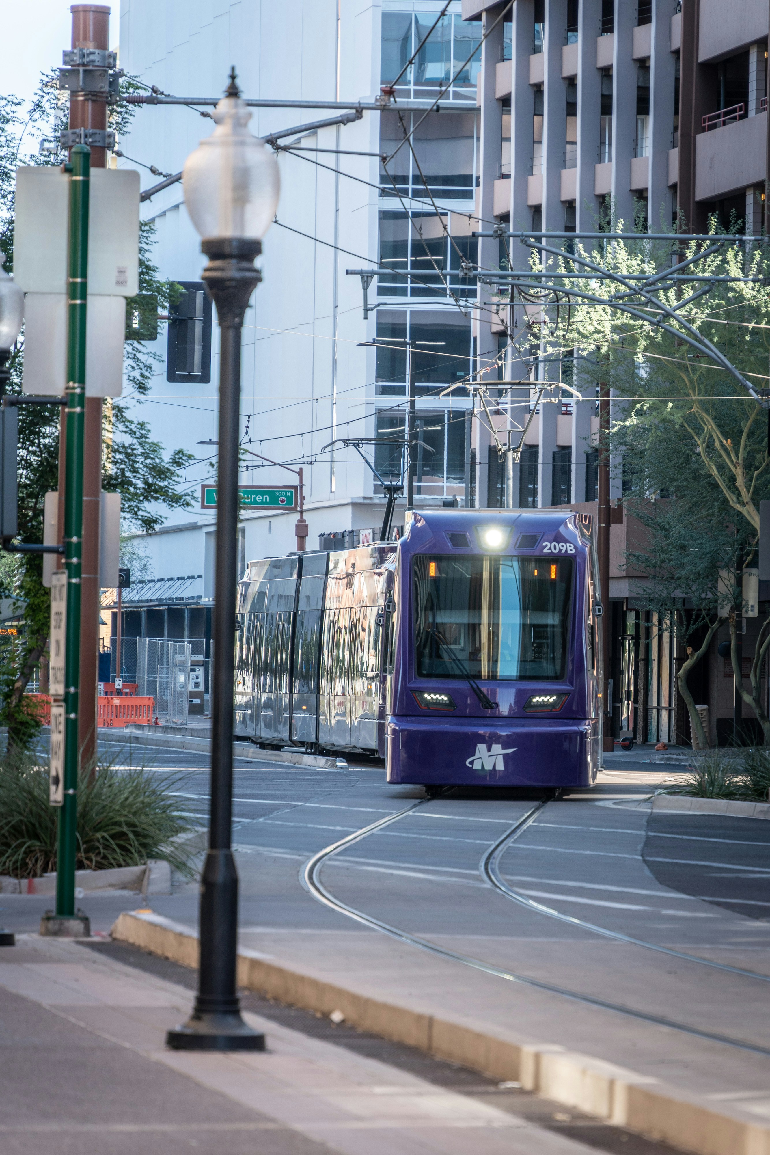 Purple Streetcar Glide: Urban Rails Through Cone-Shaped Light