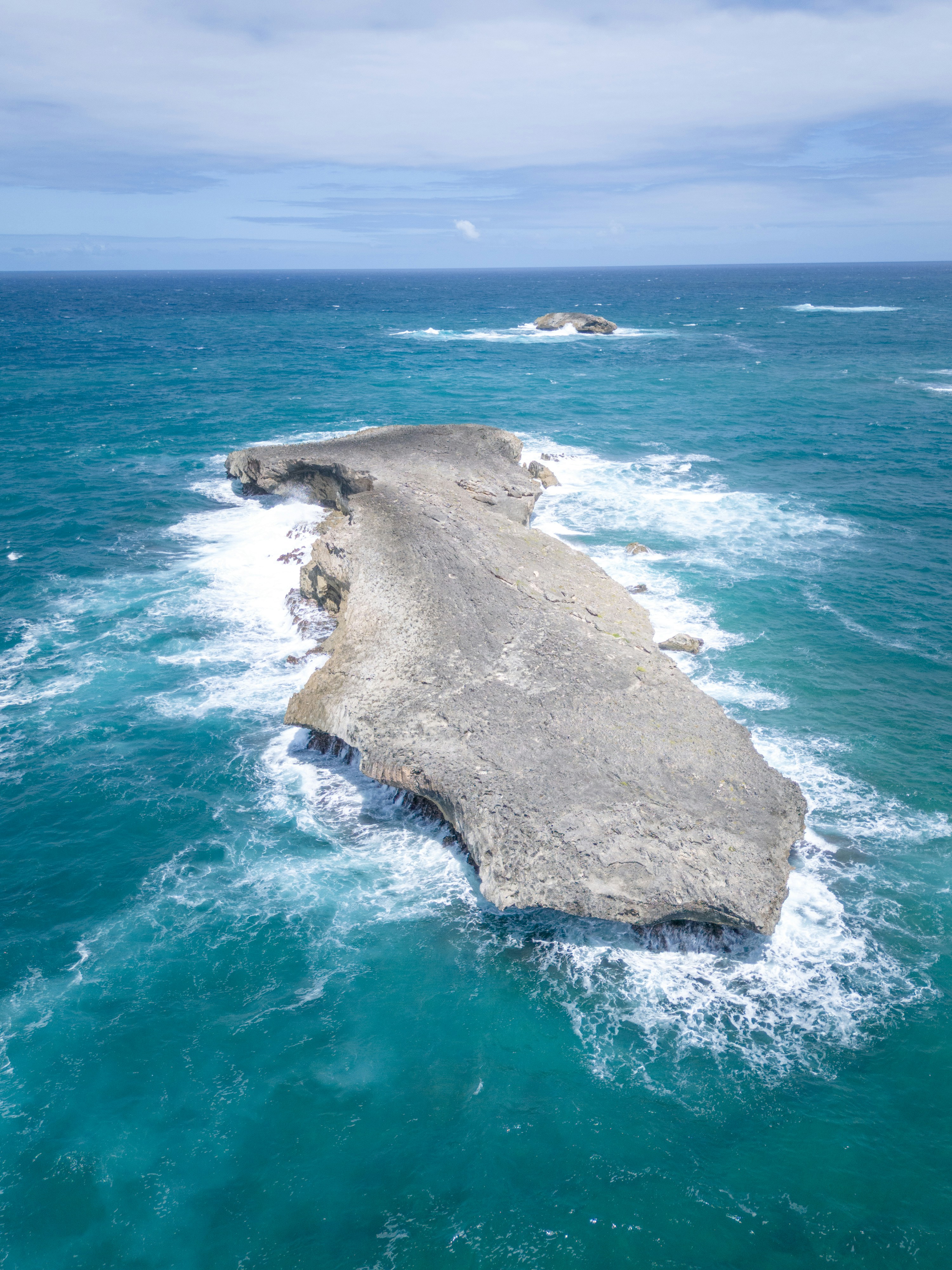 Sea-Scale Break: A Shaped Sea-Rock Extends into Turquoise Waters