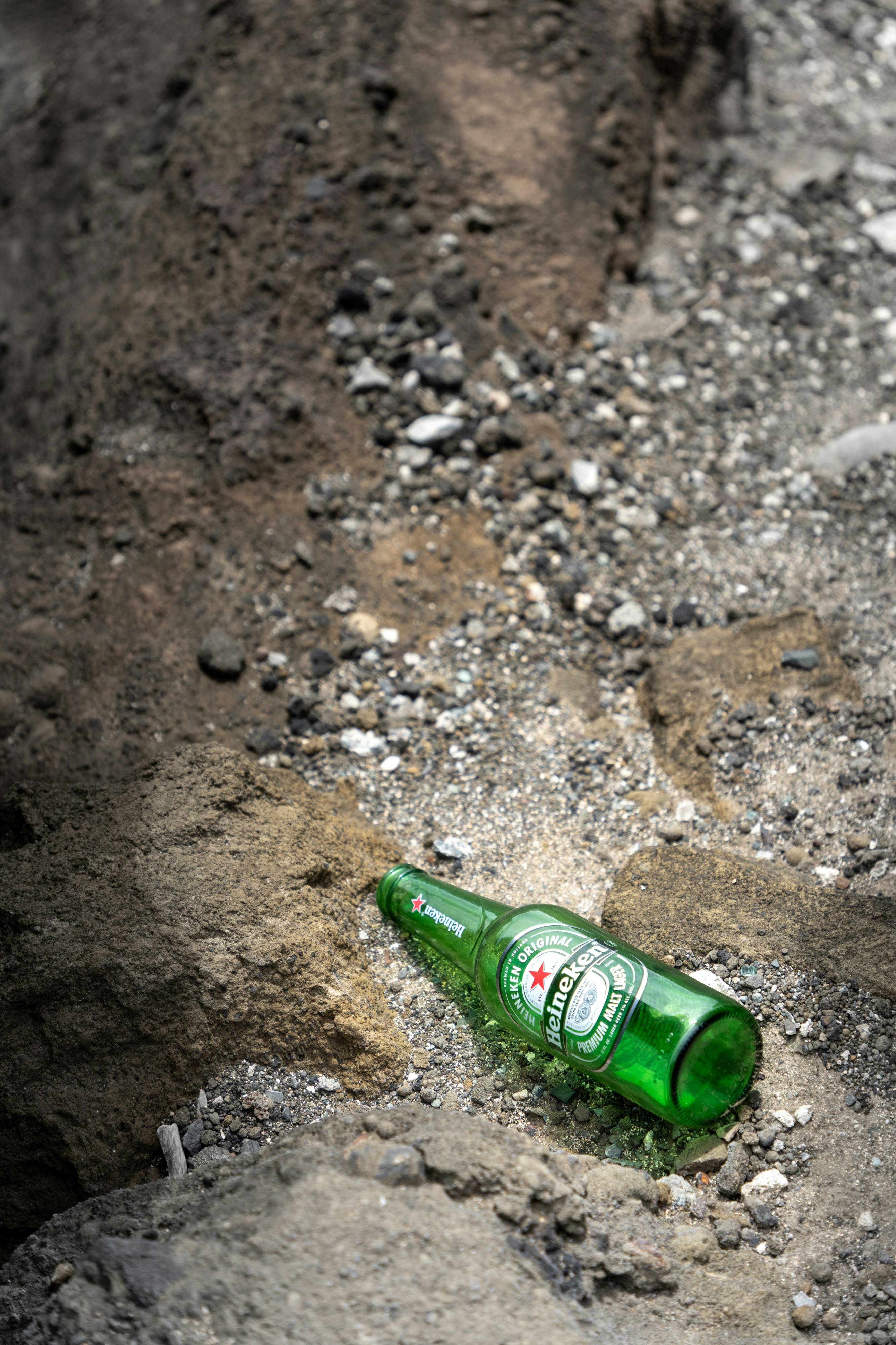 Green Heineken Bottle in Gravelly Ground