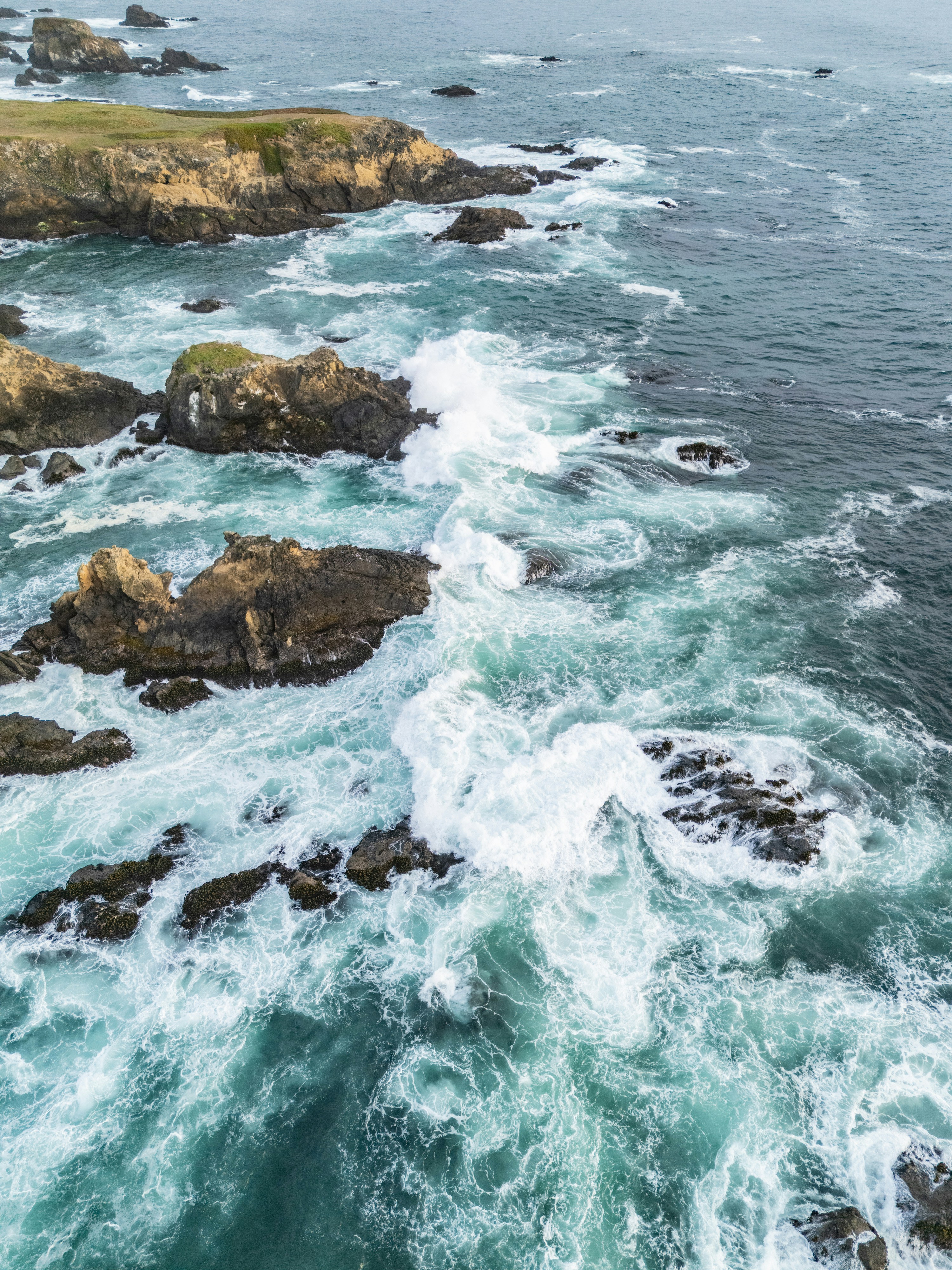 Rugged coastline and frothy tides carving through jagged rocks