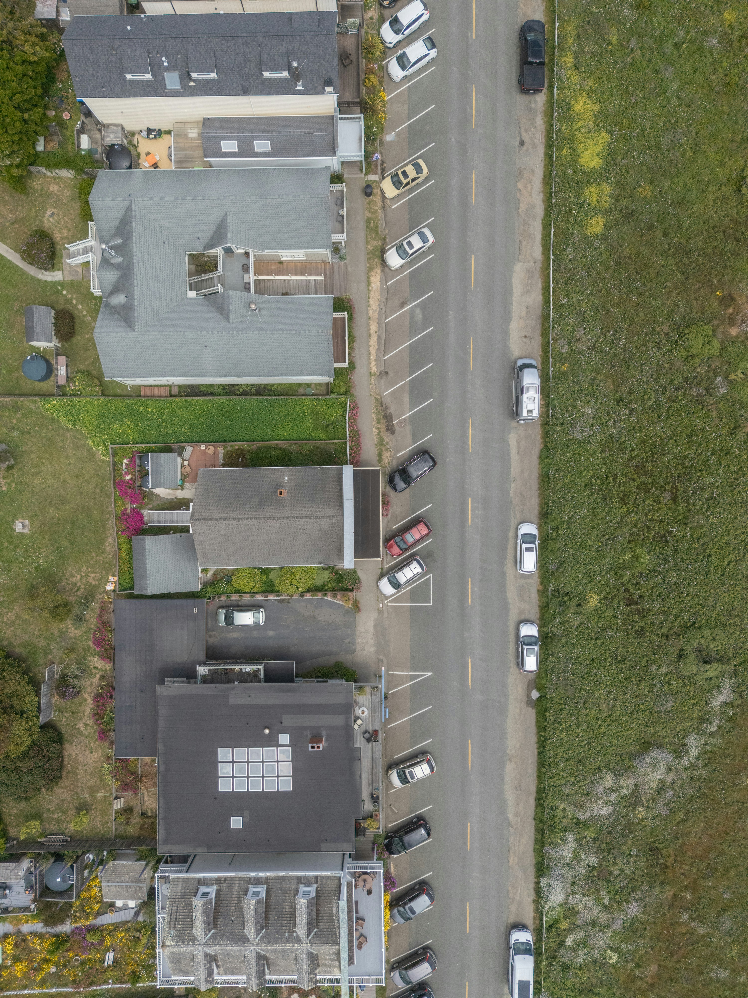 Aerial Row: Cars Nestle Along a Narrow Street Between Quiet Homes