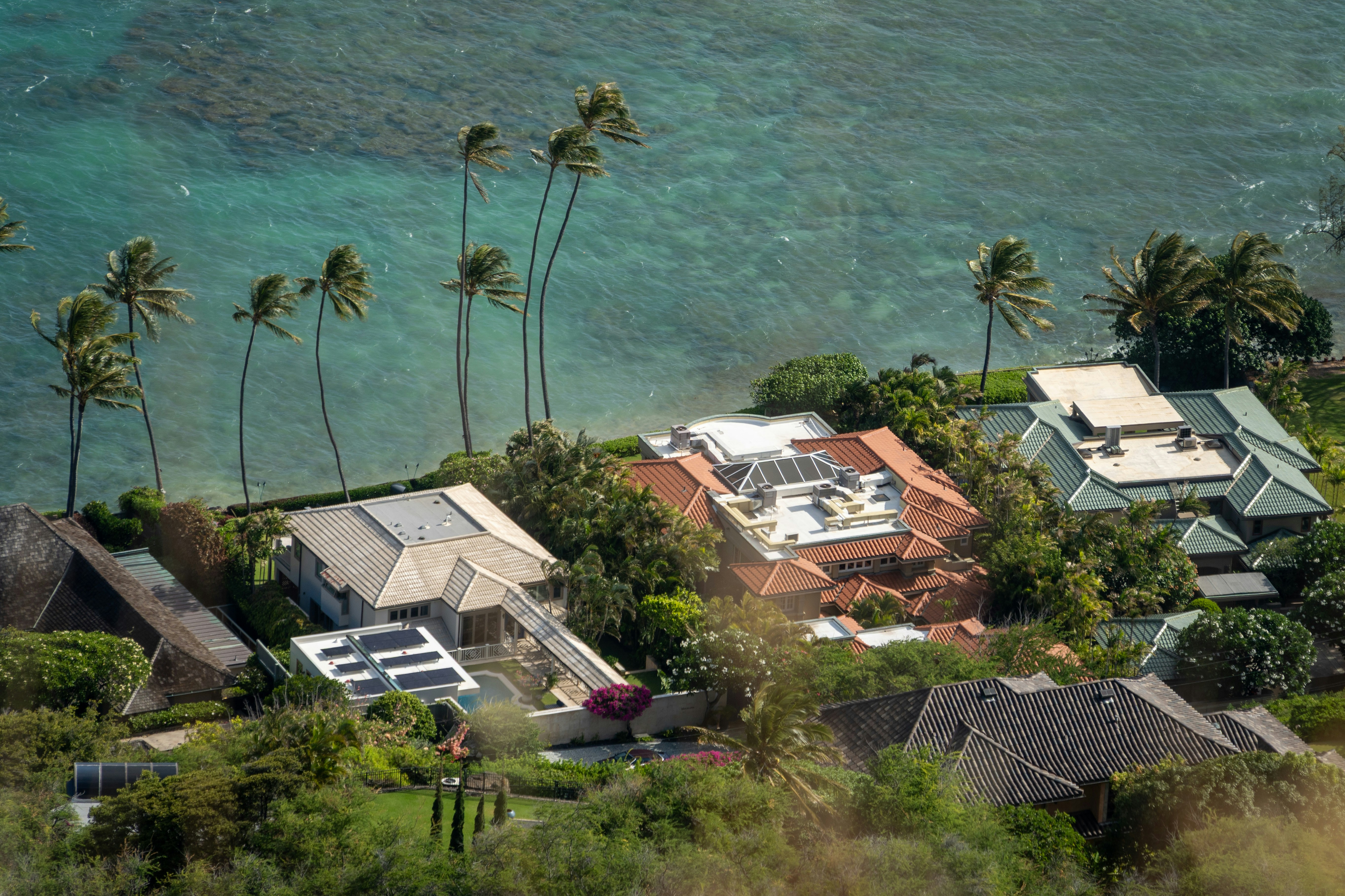 Coastal Cliffside Retreats: Aerial Row of Tropical Homes Beside Turquoise Waters