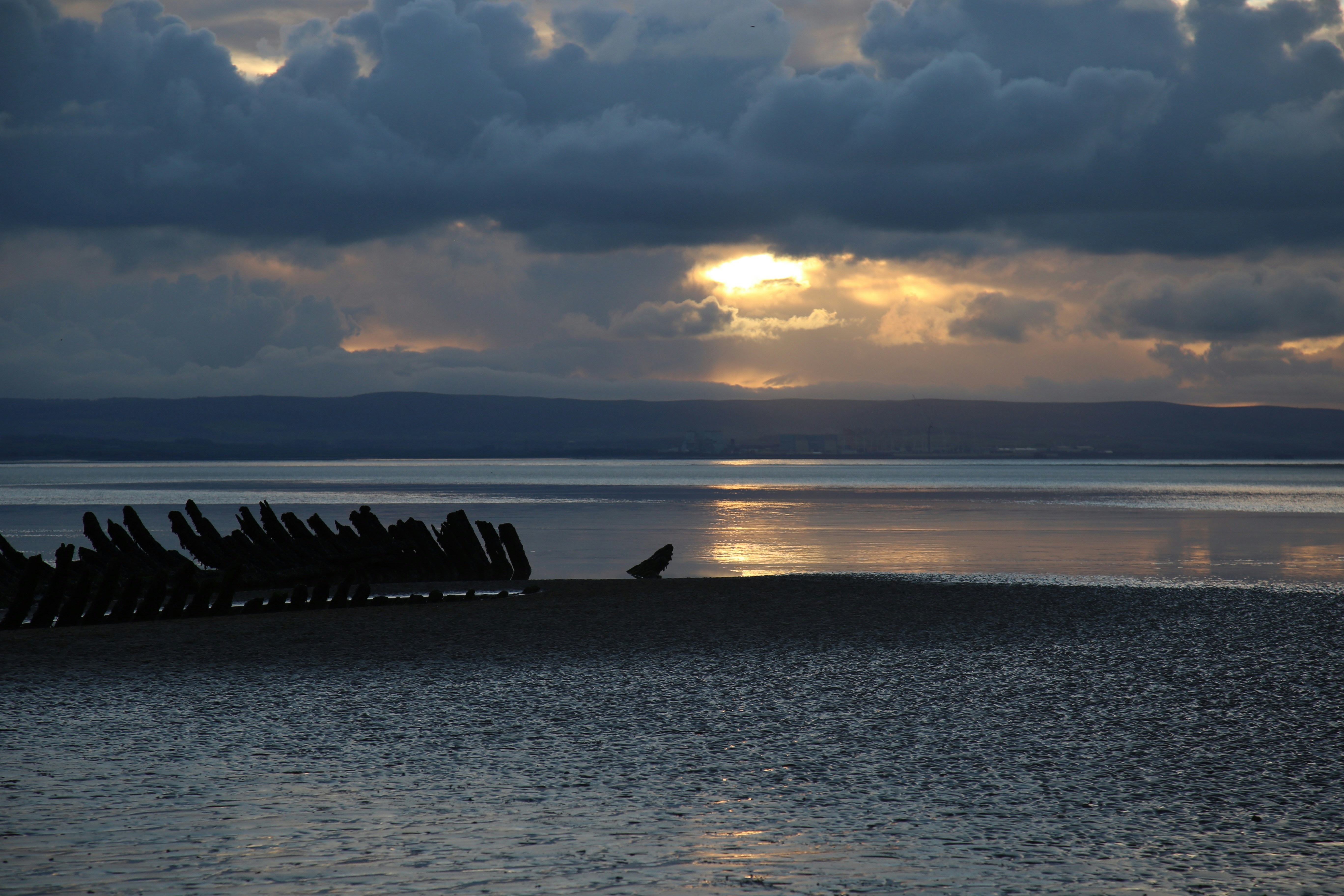 Distant Sunset over a Quiet Tidal Flat with Weathered Piling