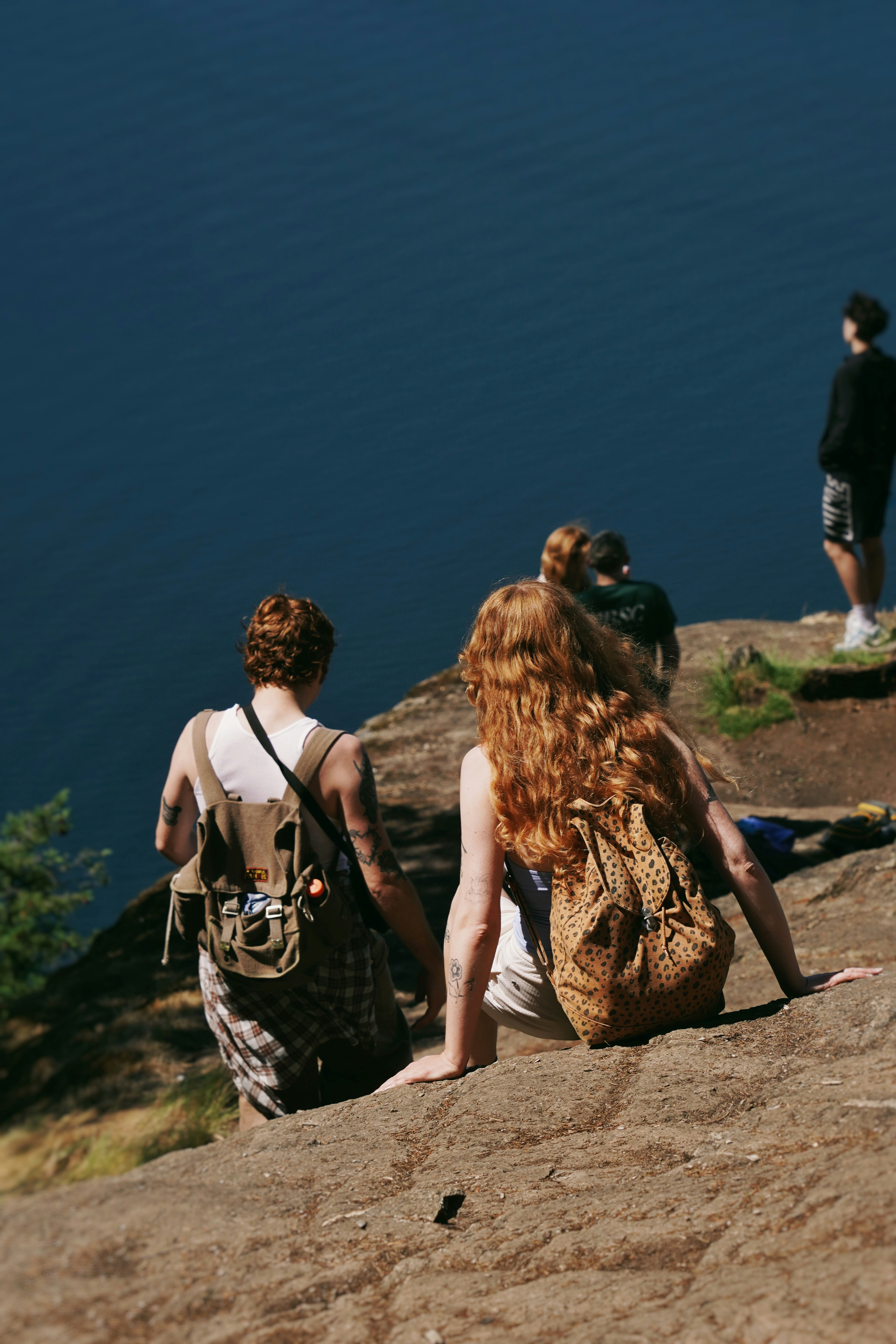 Edge of the World: Friends Perched on a Cliff Above Blue Silence
