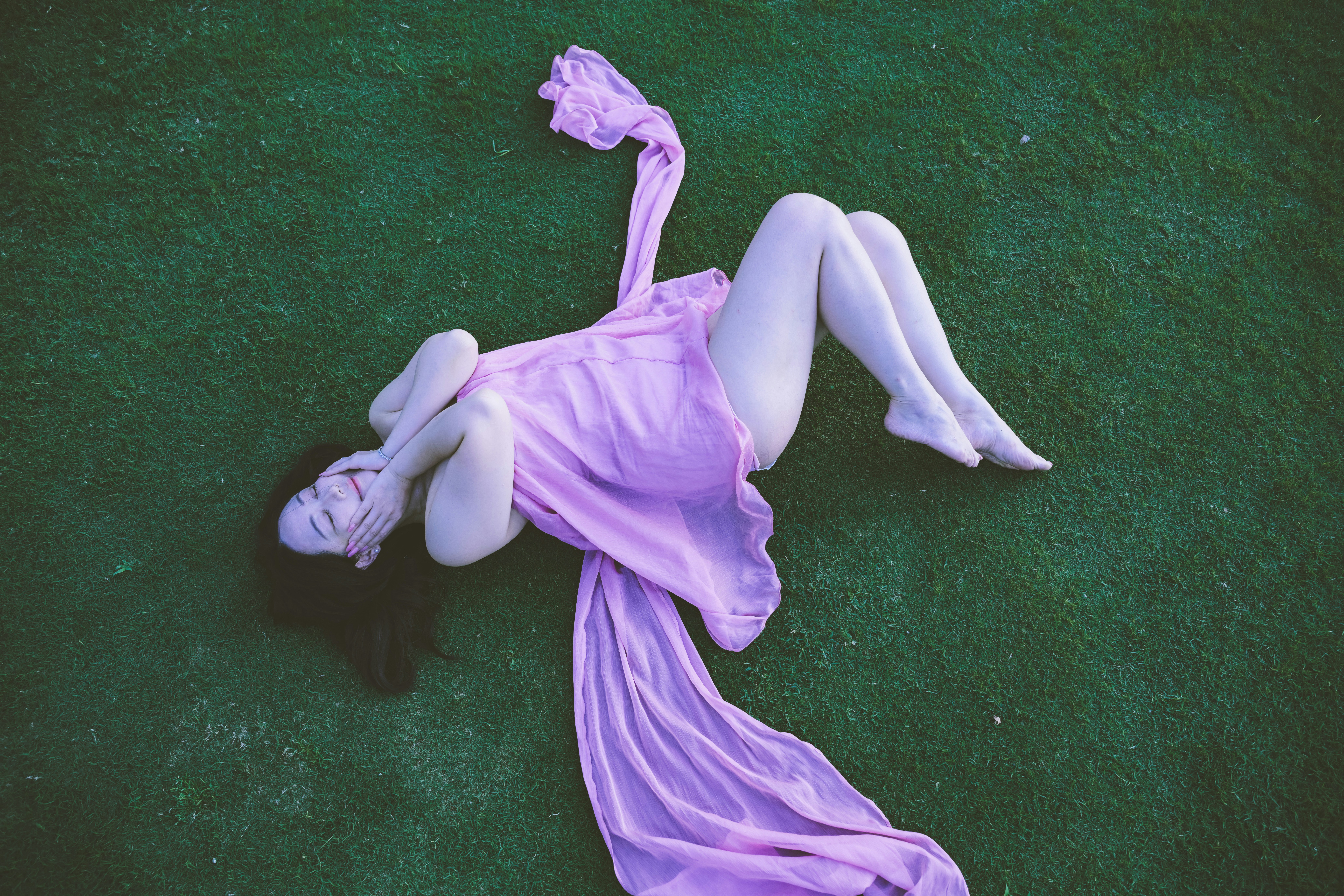 Lilac Draped Silence: A Woman Resting on Green Velvet Ground