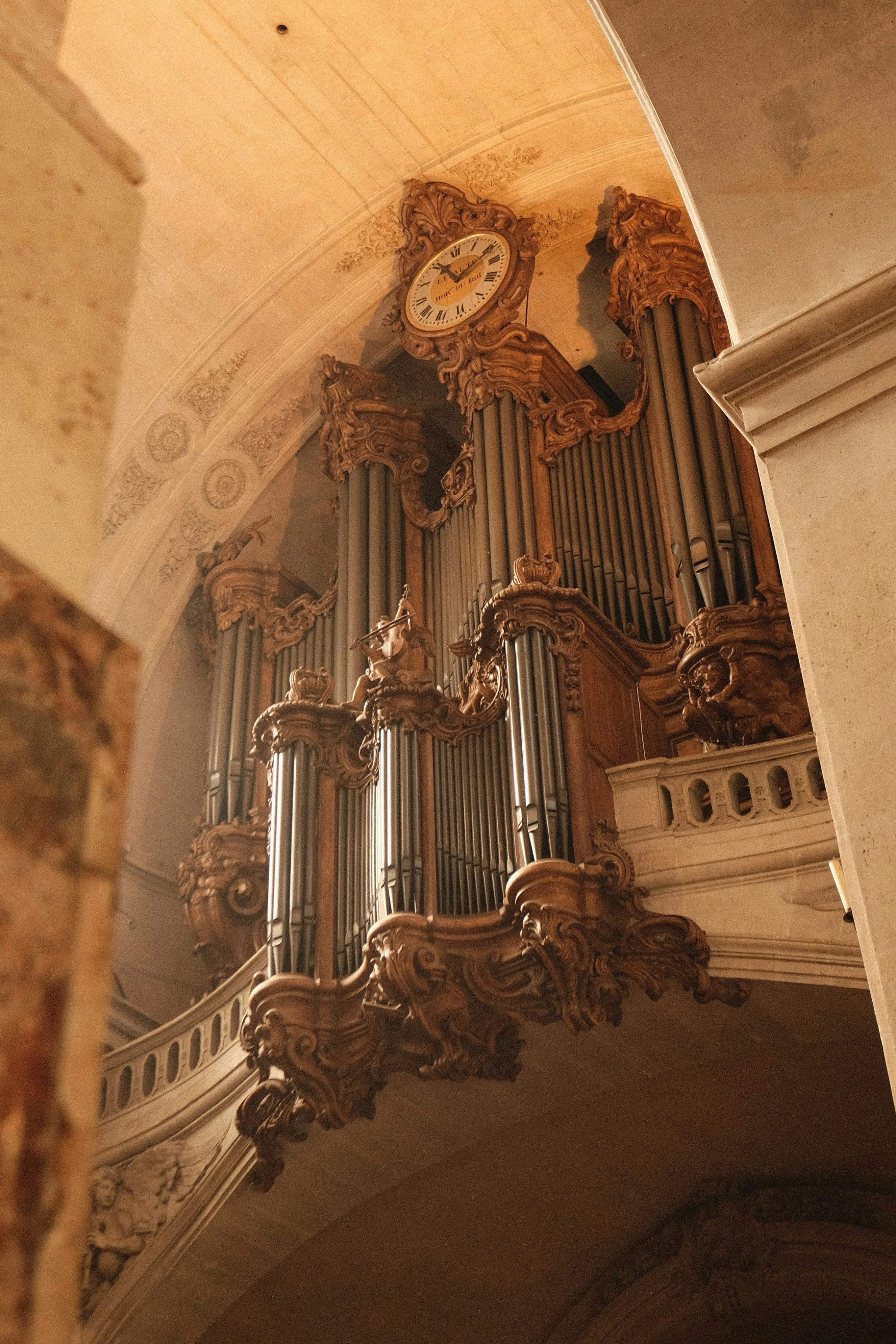 Ancient Clock's Gilded Organ Crown in Dim Cathedral Light