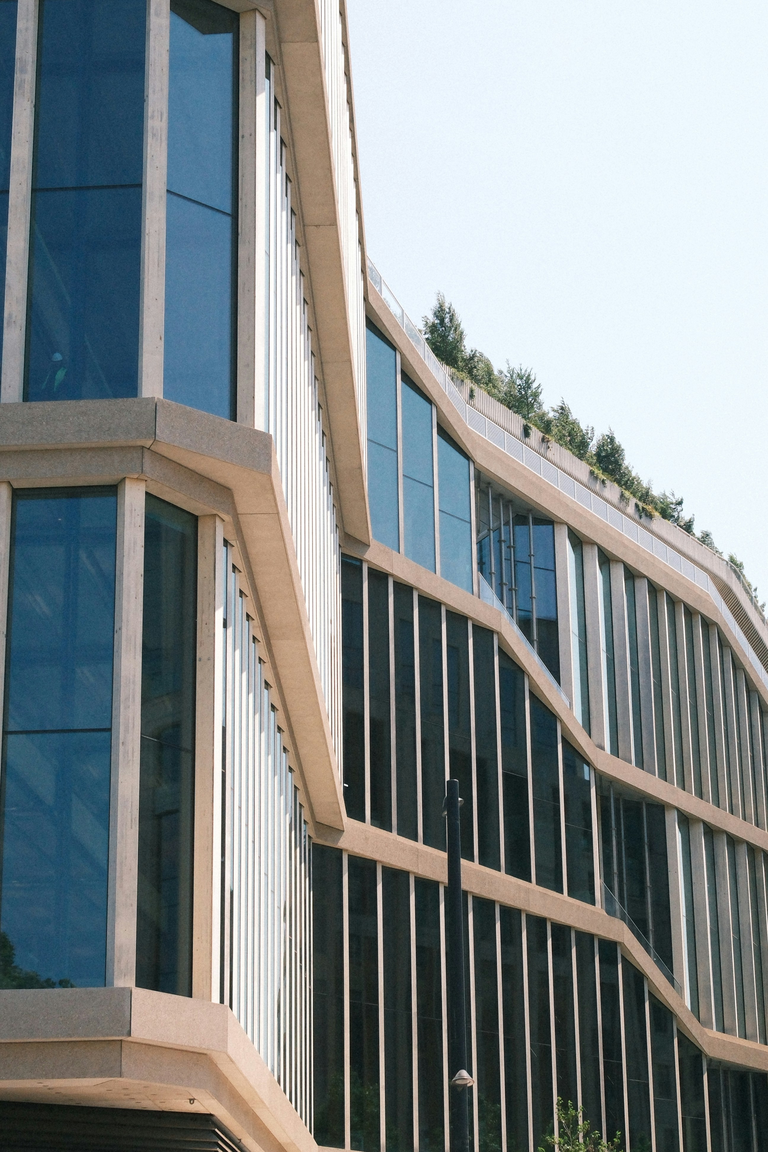 Curved Glass Facade: Sunlight Tracing a Modern Office Spine
