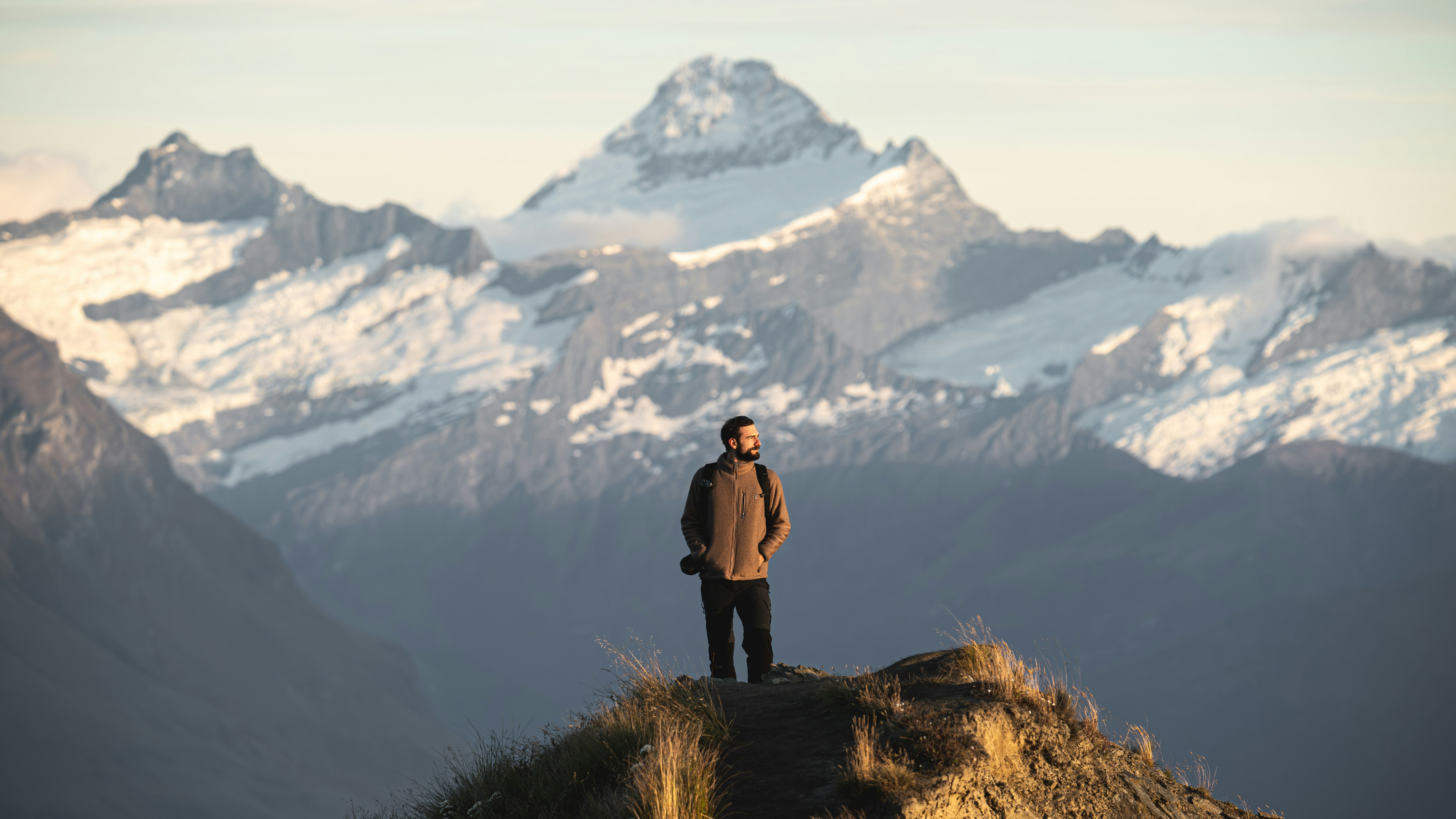 High Summit Sentinel: A lone hiker overlooking a jagged alpine panorama