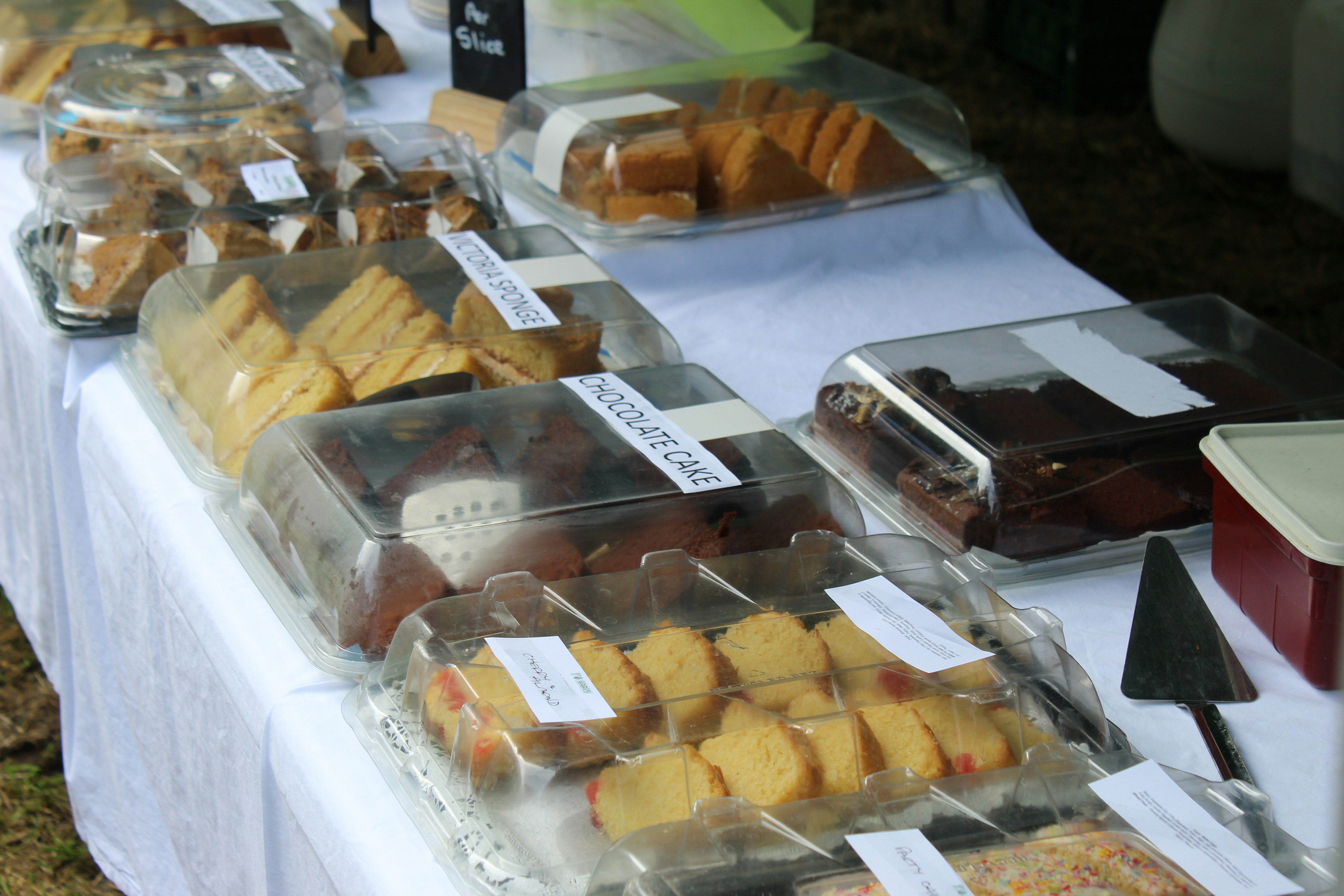 Sliced Cakes and Pastries Parade on a White Tablecloth