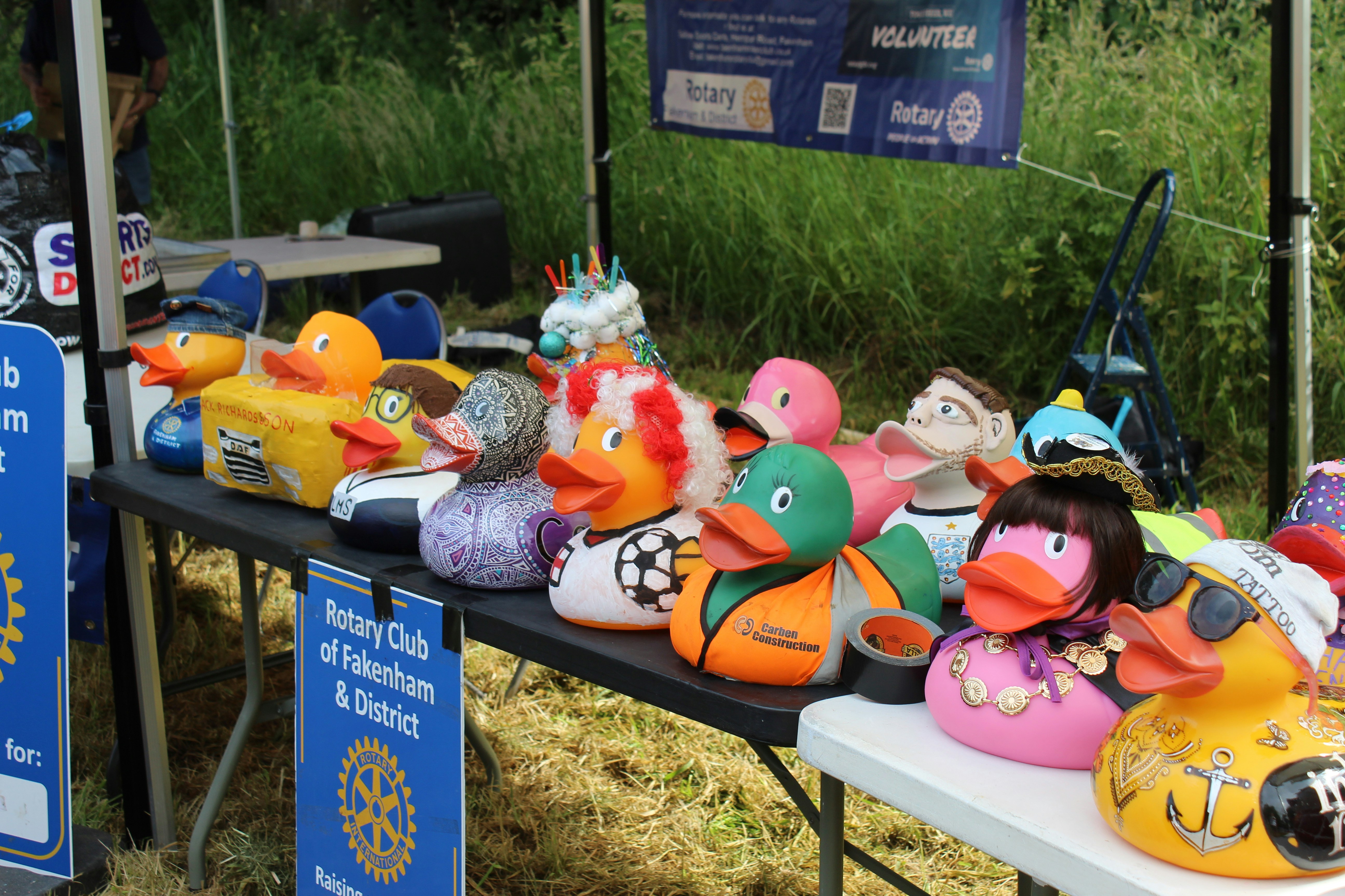 Colorful Duck Mascots Stand Guard at Rotary Charity Booth