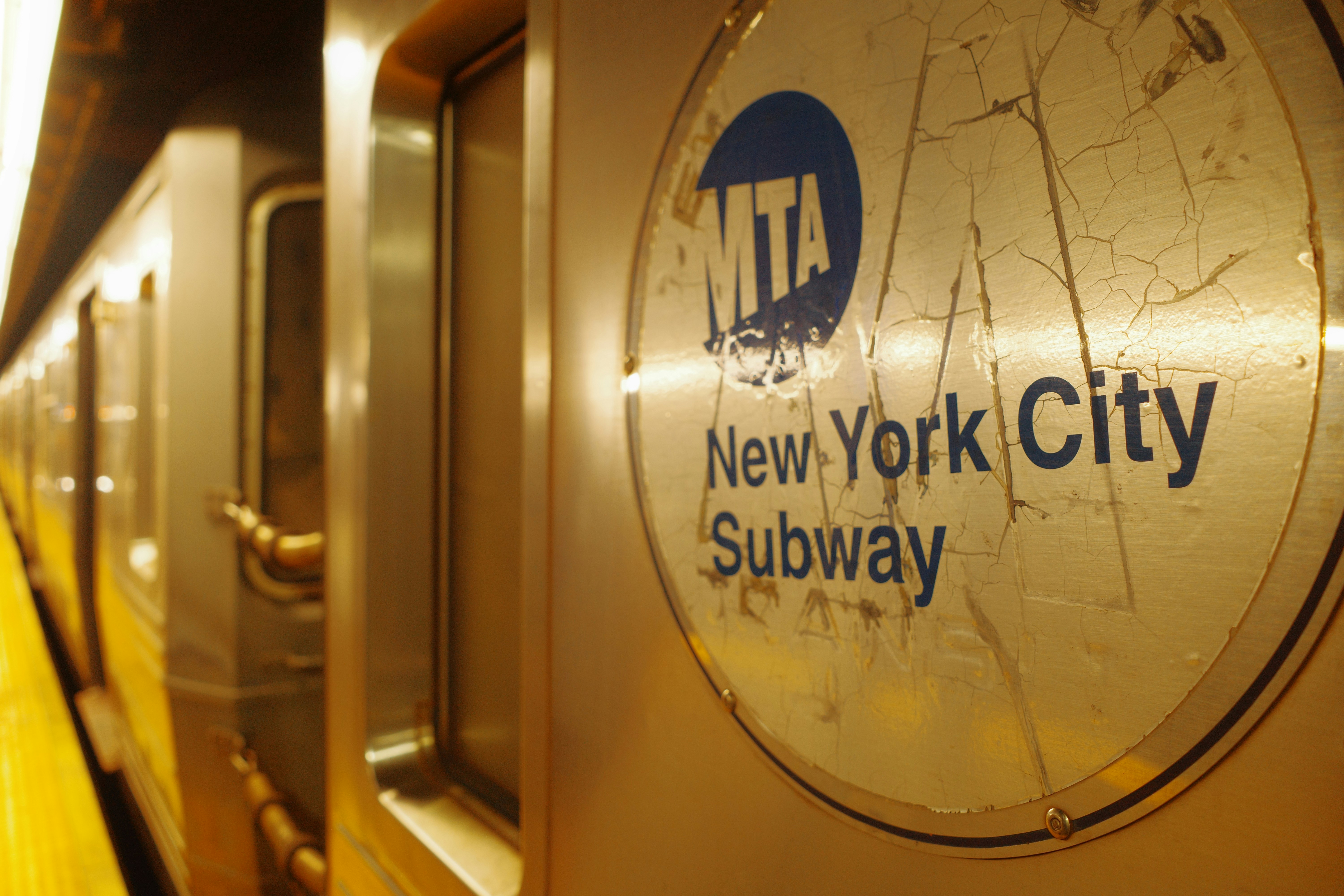 Echoes of the Platform: A Close-Up of a Weathered NYC Subway Sign