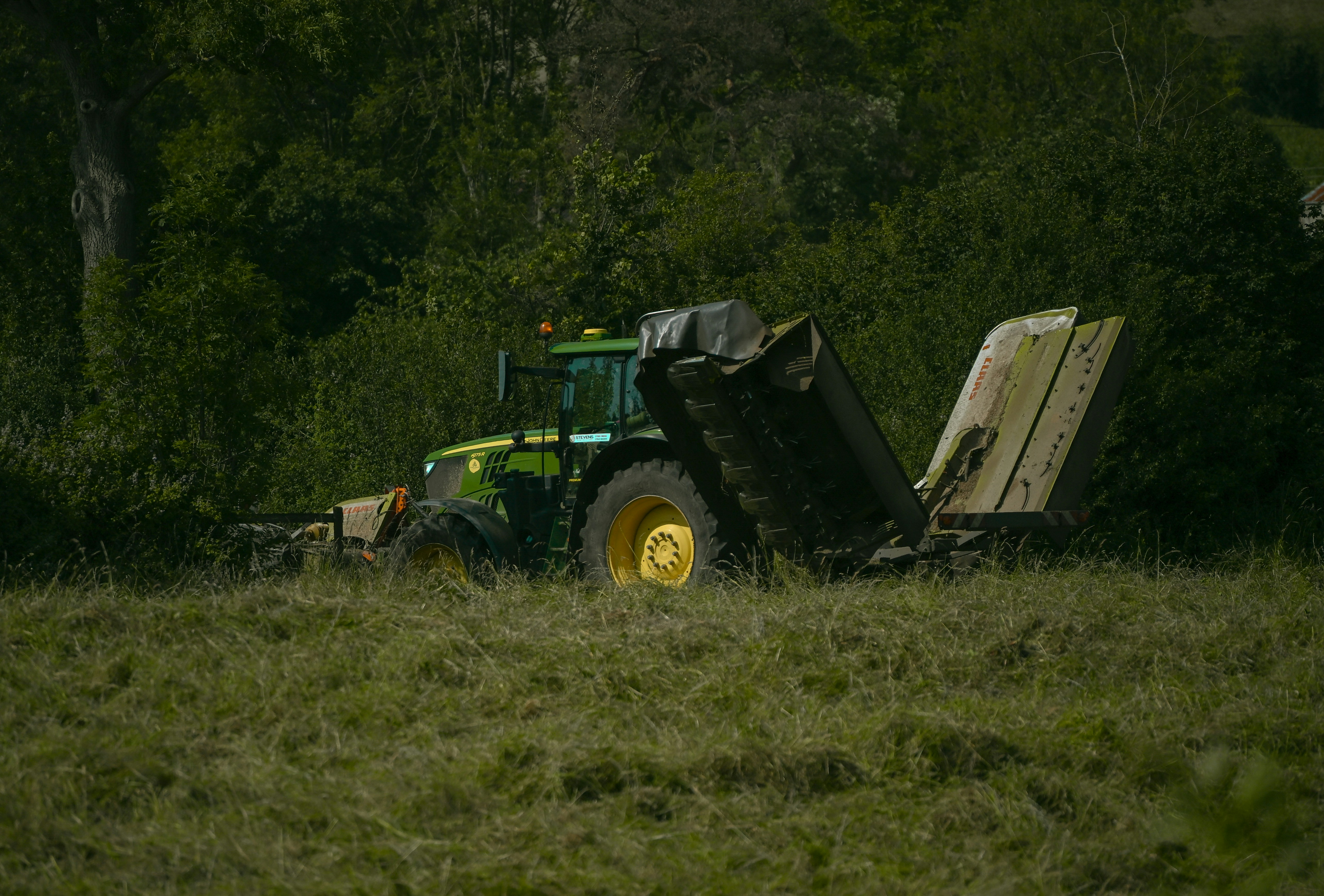 Green Tractor in a Hearty Field: Dust and Machinery in Morning Light