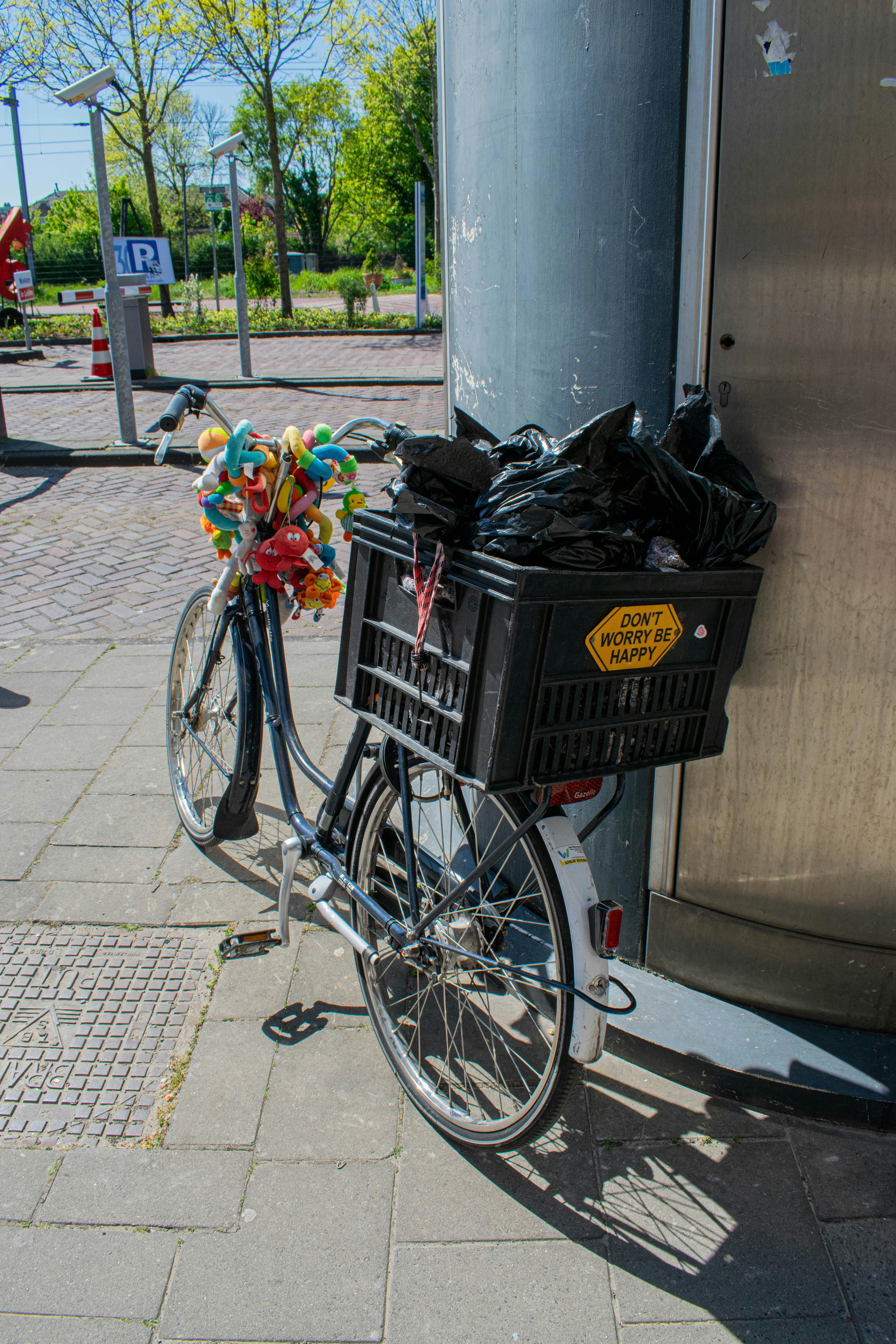 Delivery Bicycle: A Colorful Toy-Decorated Ride by the Trash Basket