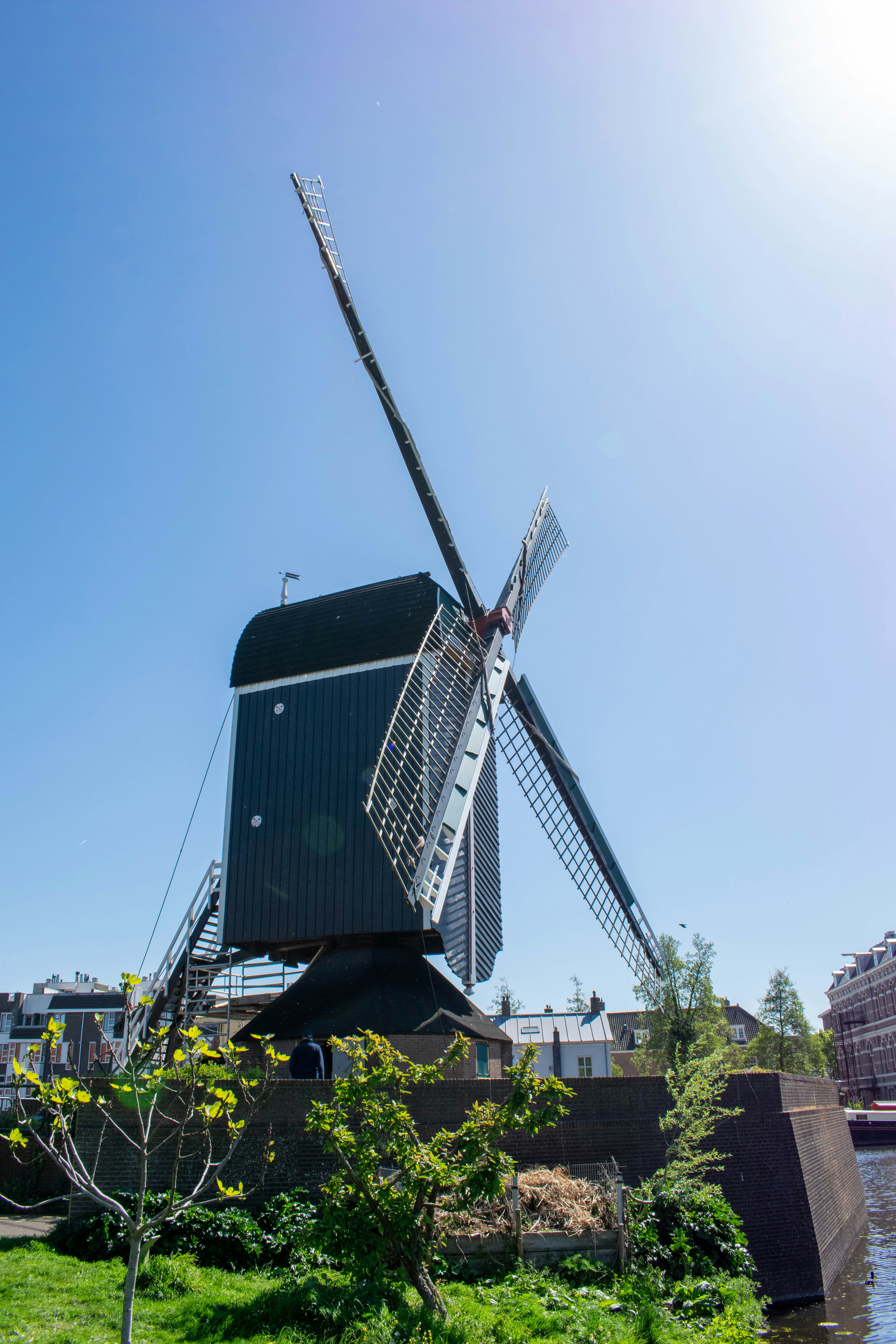 Sunlit Dutch Windmill Overlooking a Riverside Quarter