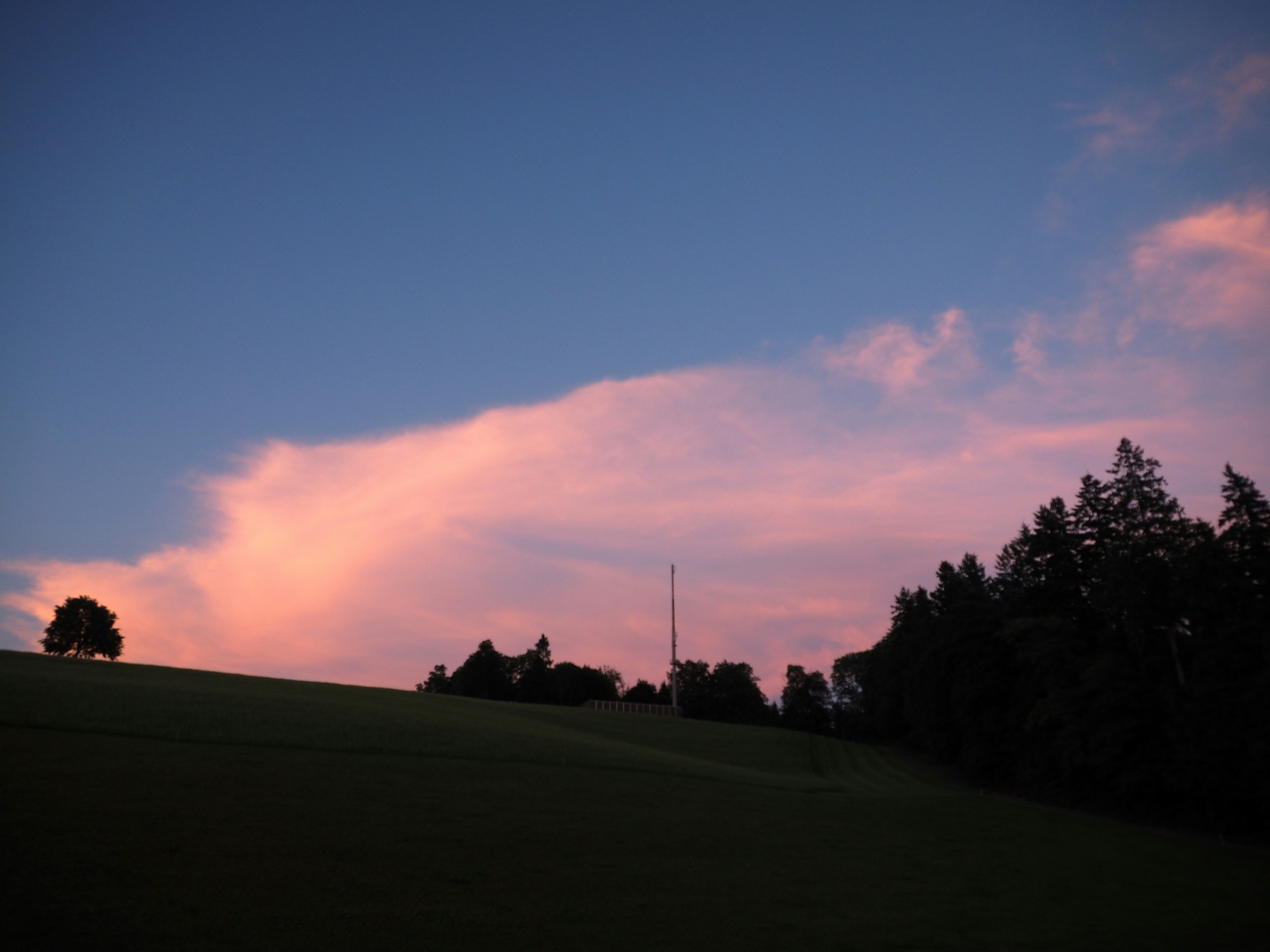 Sunset on the Crest: Silhouetted Hill and Sky