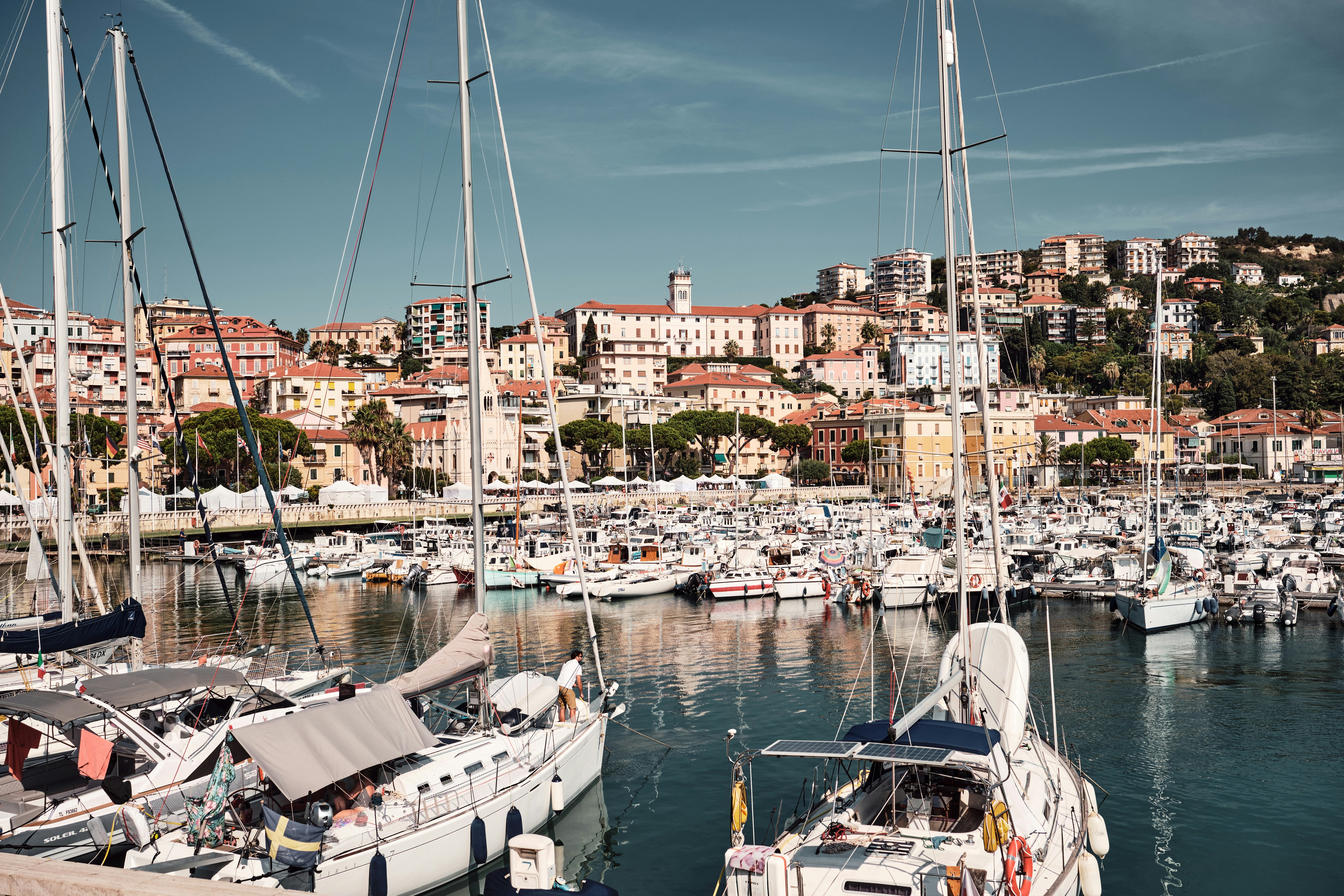 Harbor Mosaic: Sunlit Sardinian Marina Framed by Sloops and Colorful Town