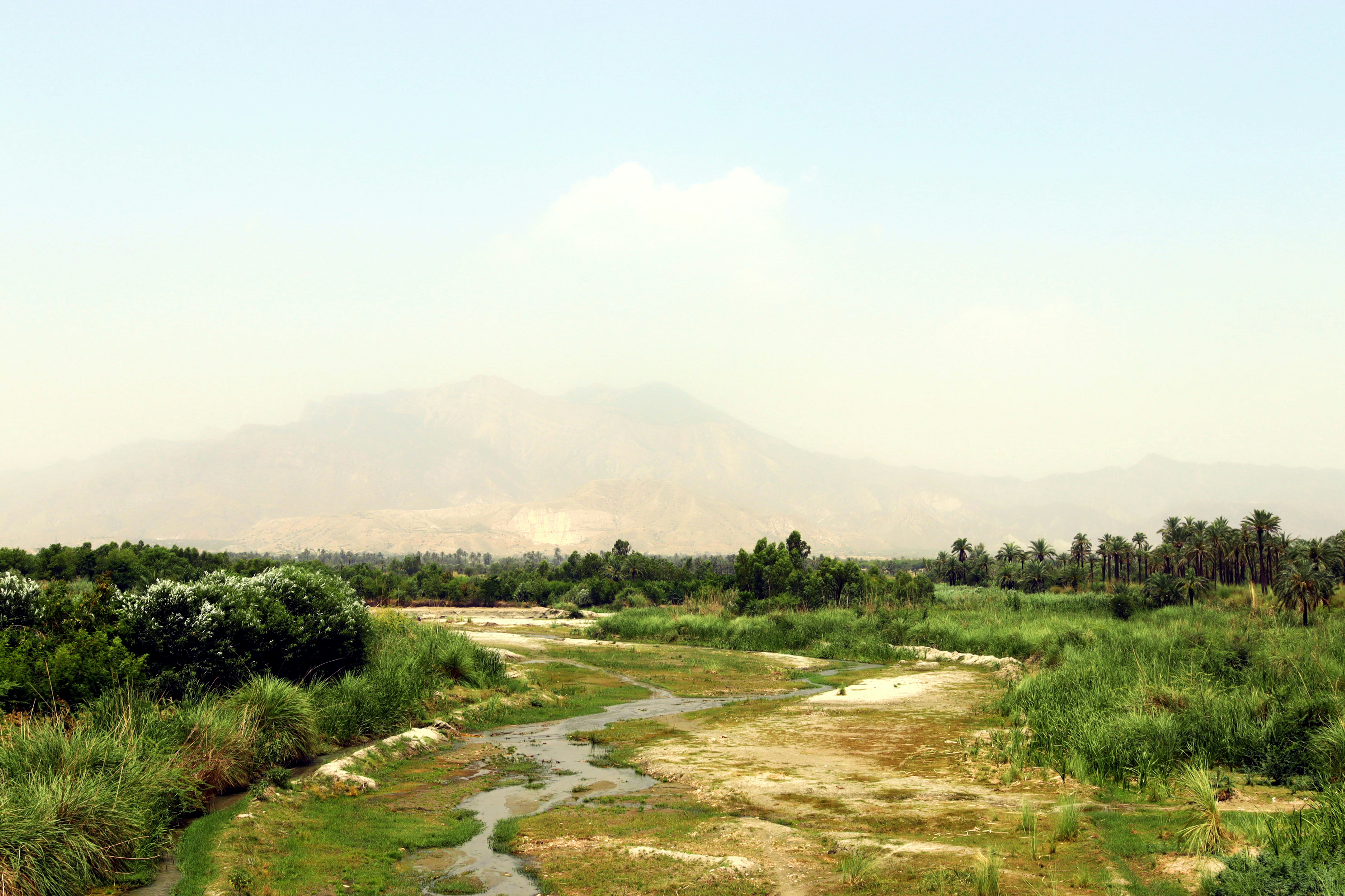Dusty riverbed under a hazy mountain horizon