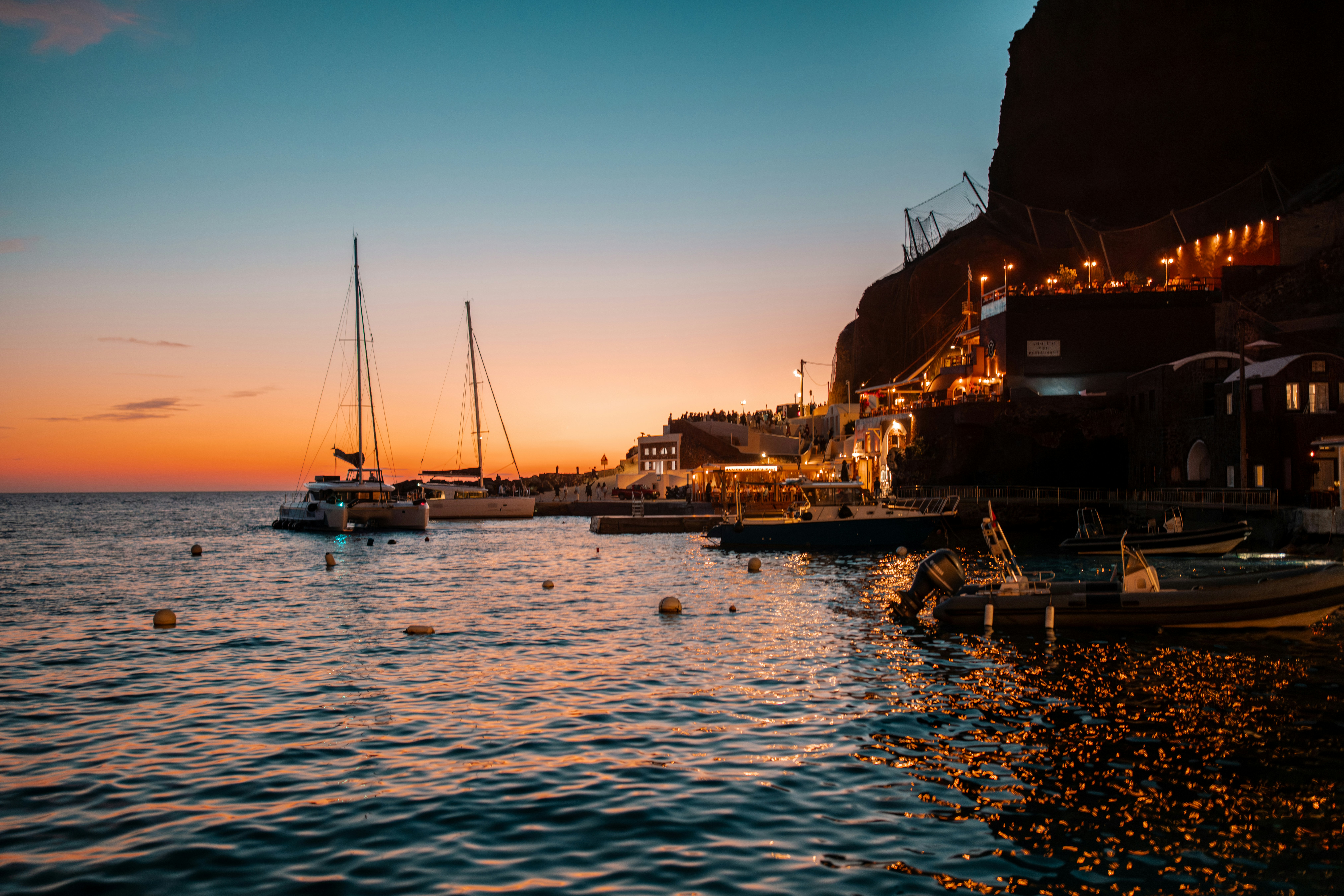 Harbor Dusk: Boats, Lights, and Cliffs