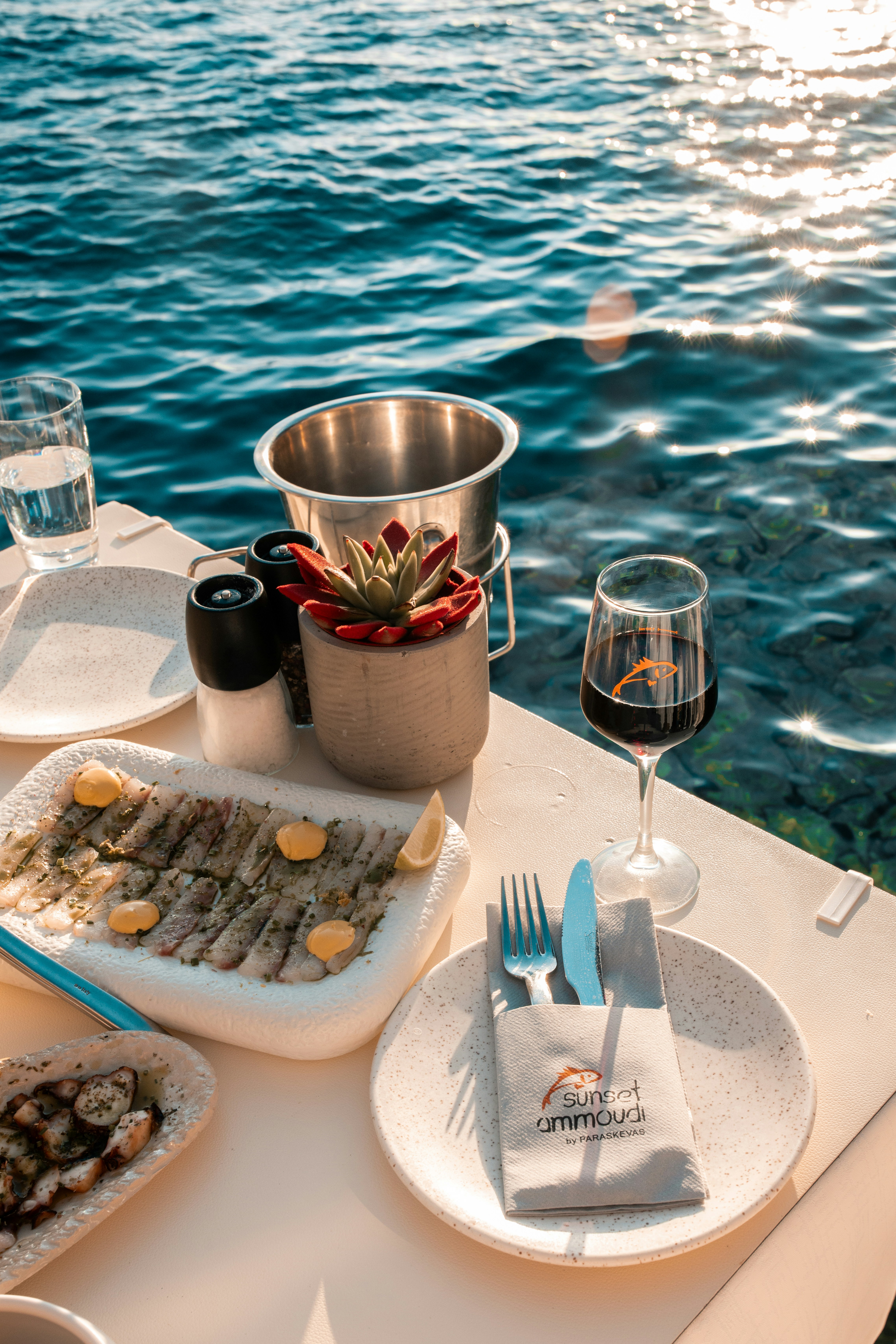 Sunlit seaside luncheon: grilled fish, wine, and a succulent centerpiece