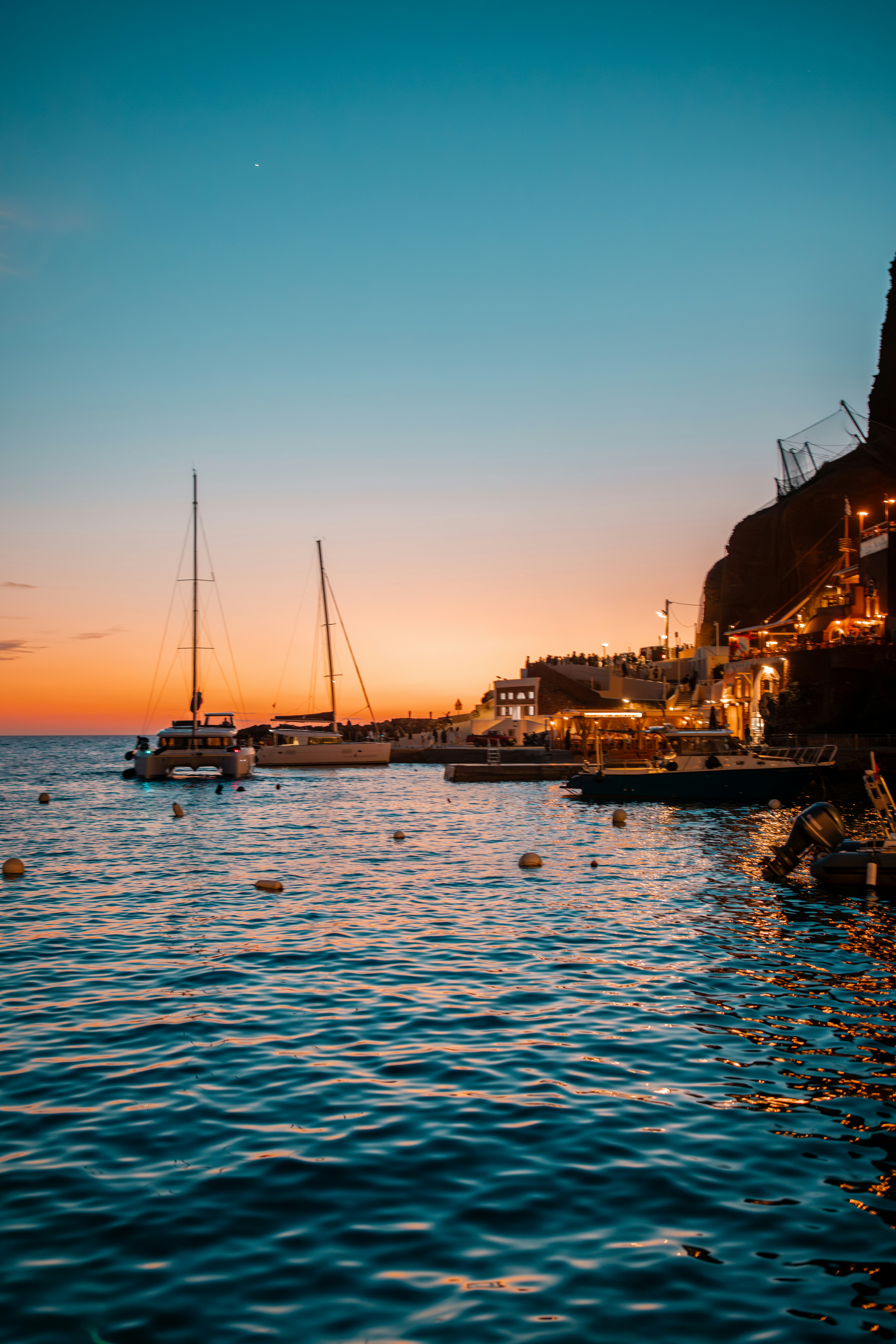 Sunset Harbor: Boats, Lights, and Cliffside Village