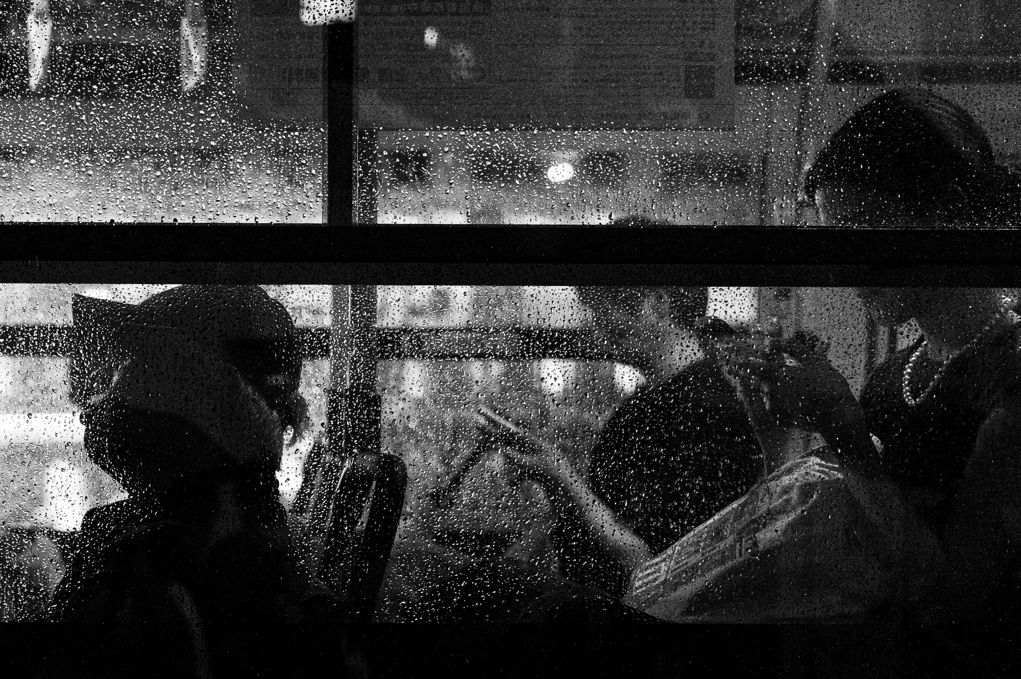 Whispers in the Glass: Silhouettes Through Rain-Streaked Bus Windows