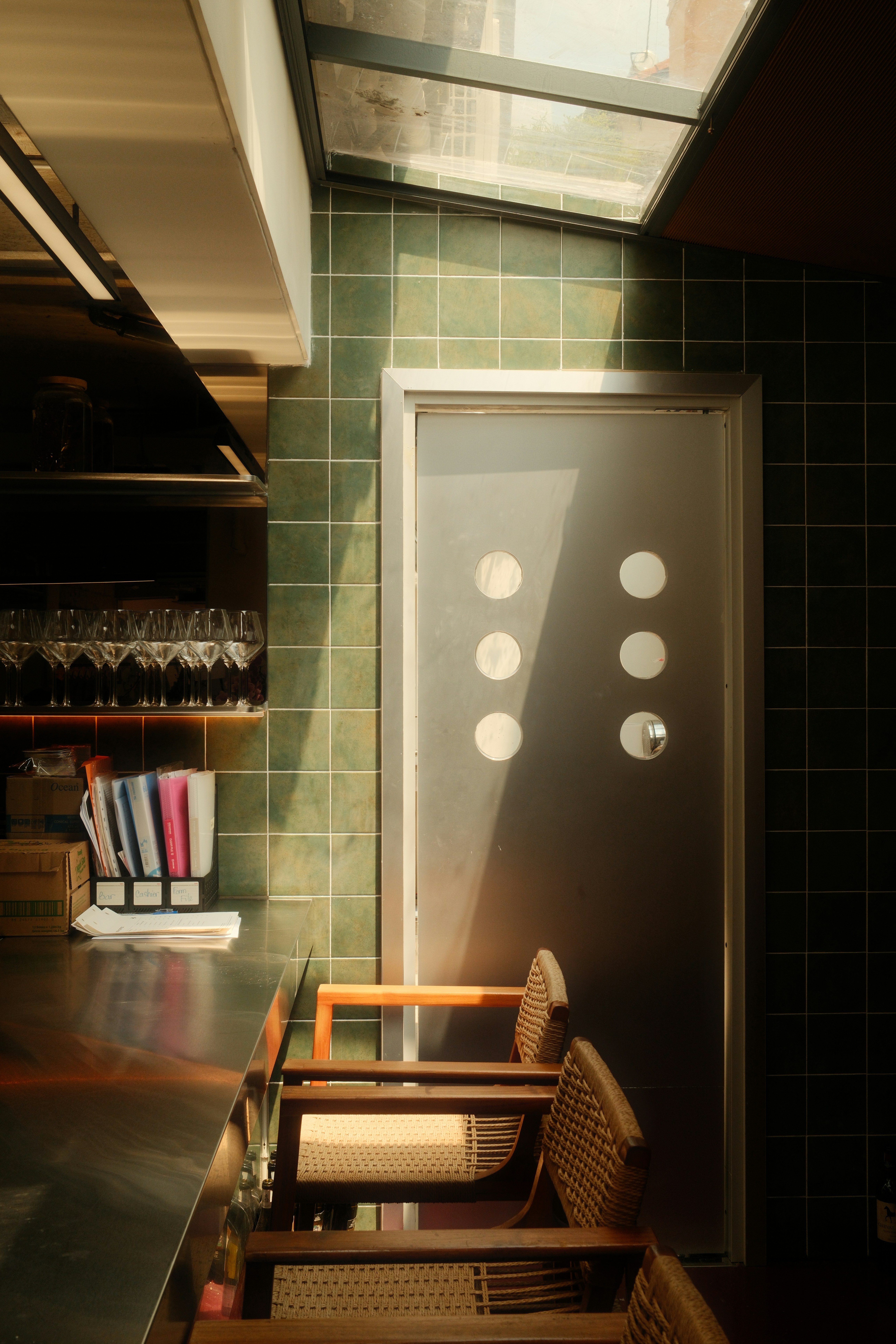 Quiet Corner of a Café Kitchen: Sunlit Door and Stacked Chairs