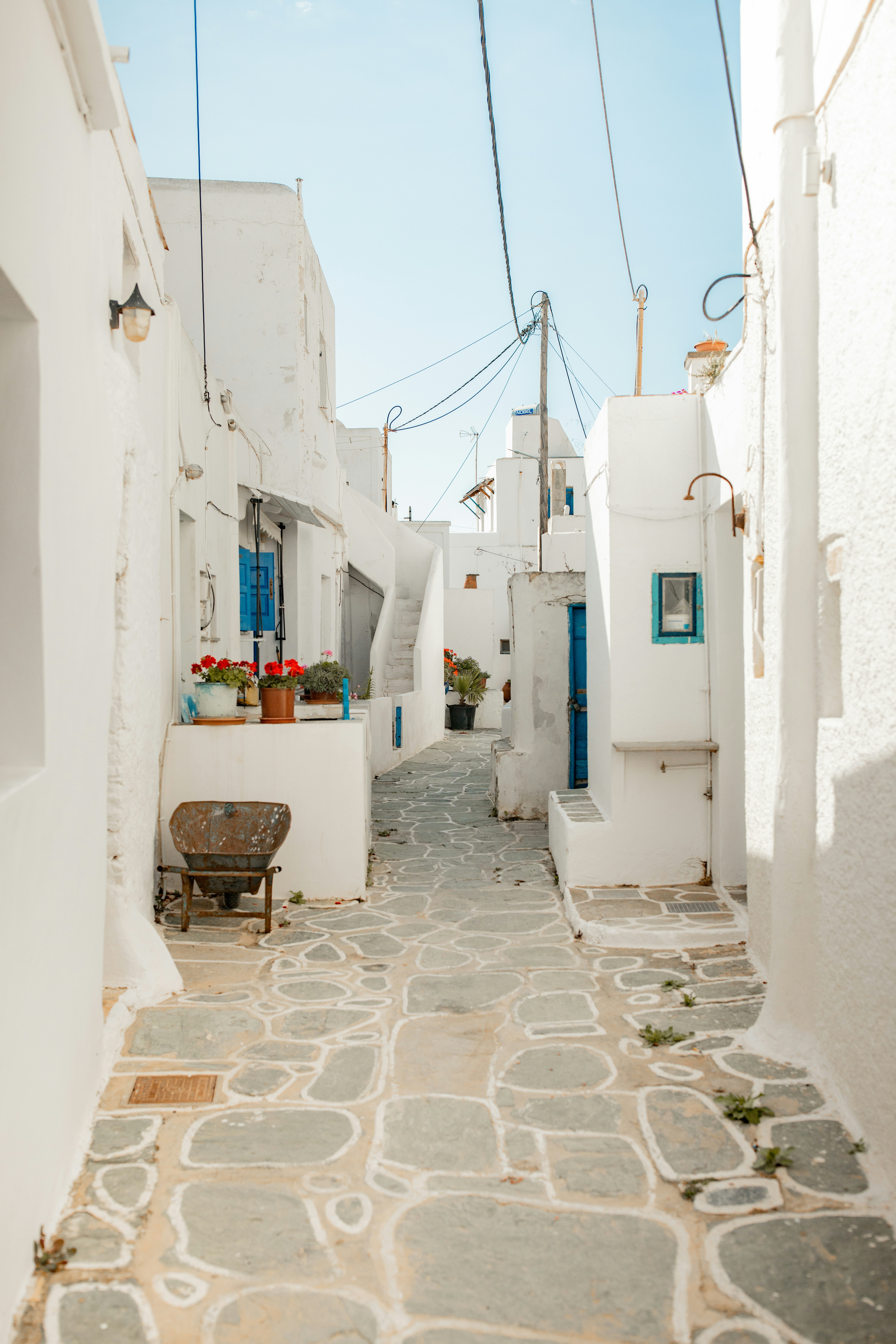 Whitewashed Callejon: Sunlit Path Through a Greek Island Alley