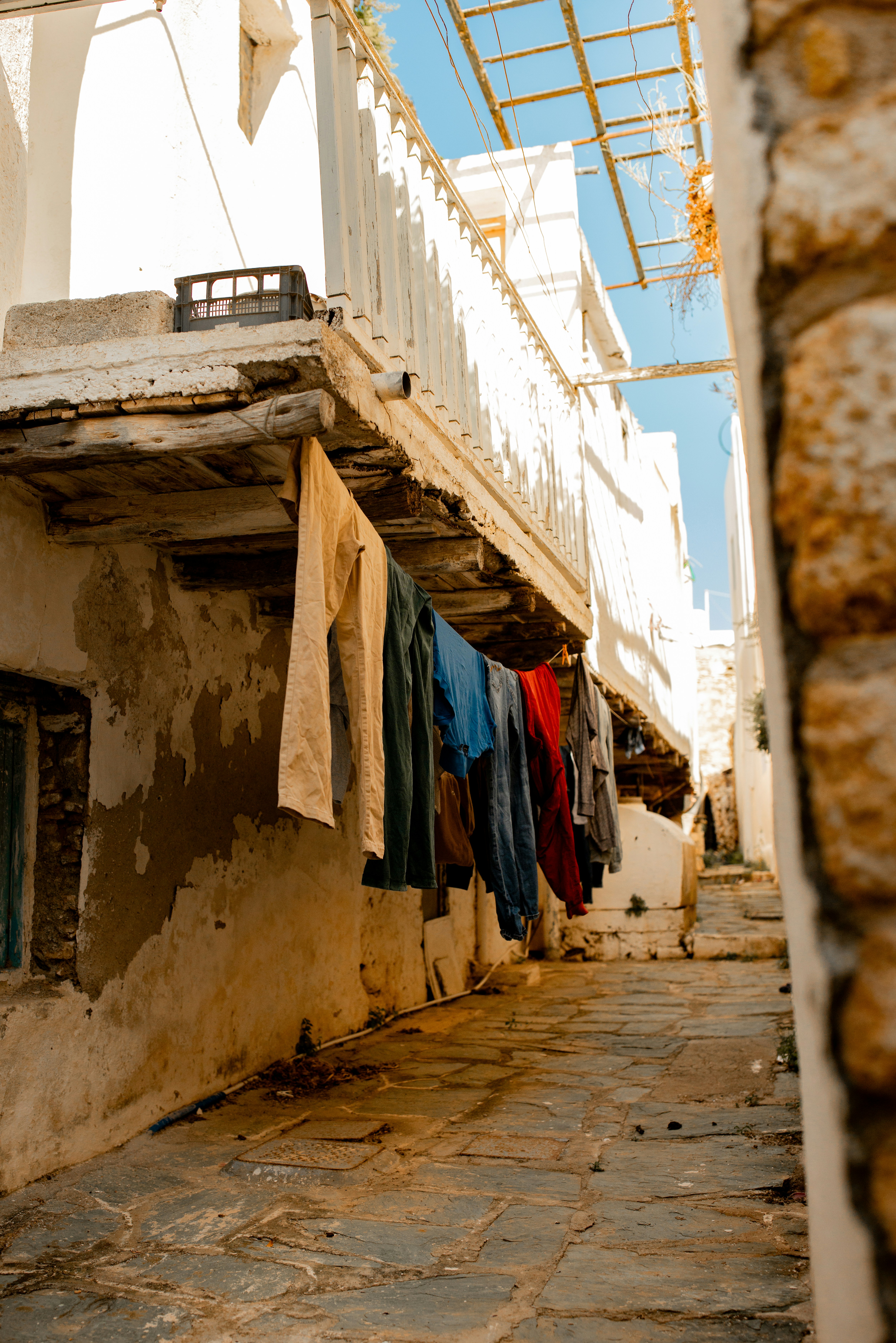 Line of laundry on a sunlit alleyway between whitewashed walls
