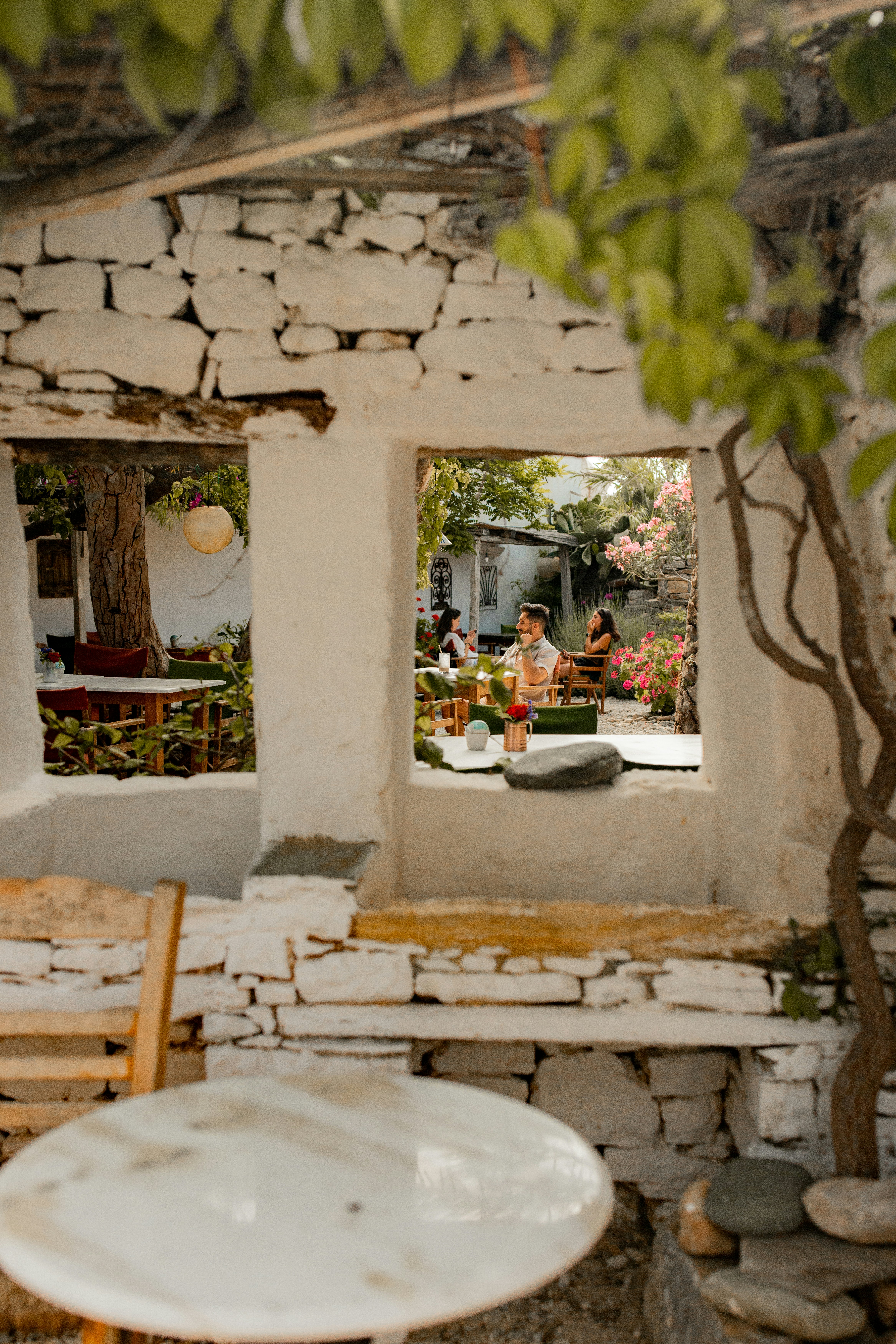Through the Stone Window: a sunlit courtyard scene framed by weathered walls