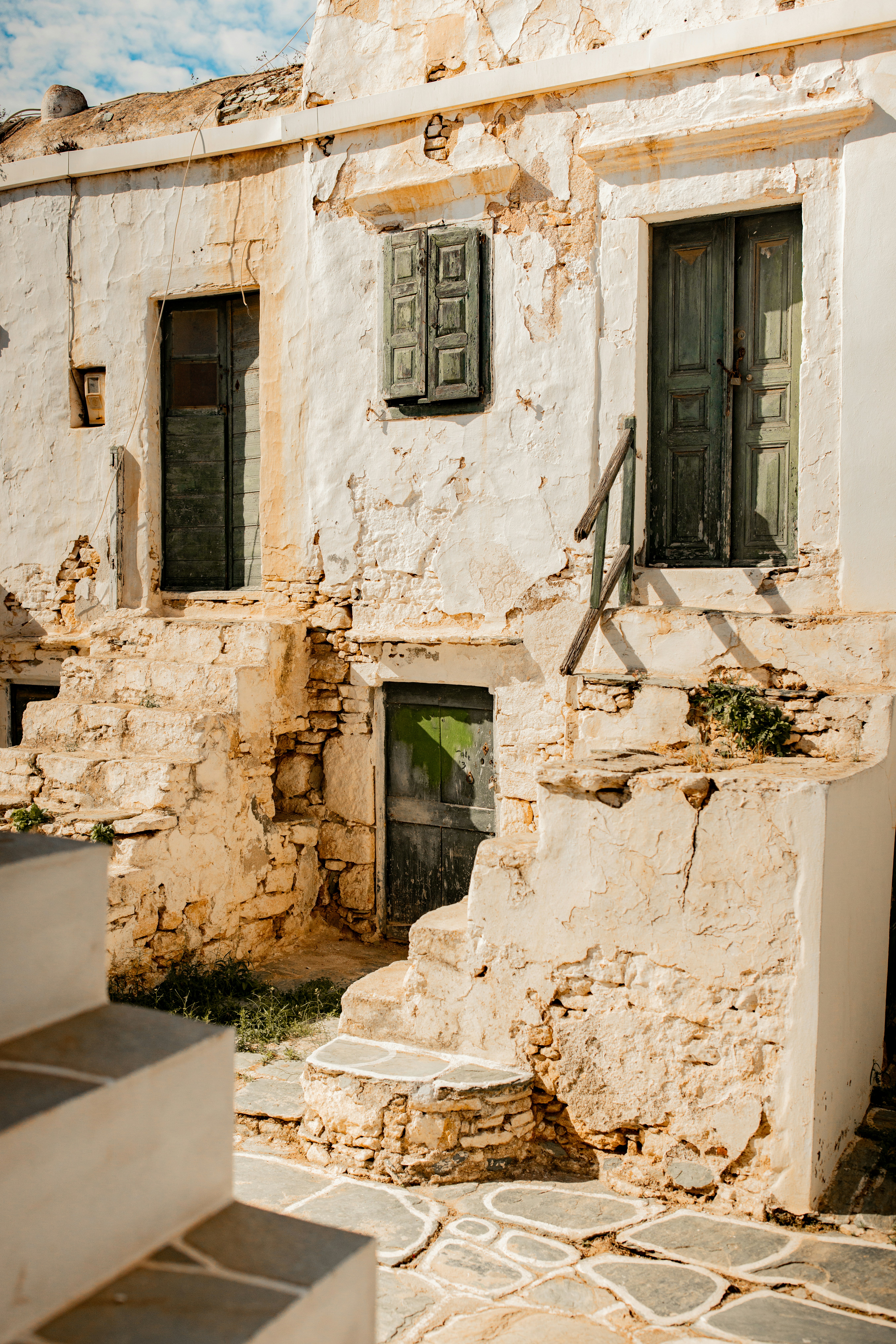 Weathered doors of a sunlit Cycladic abode